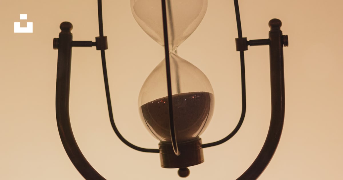 An Hourglass Sitting On Top Of A Table Photo Free Silhouette Image On Unsplash