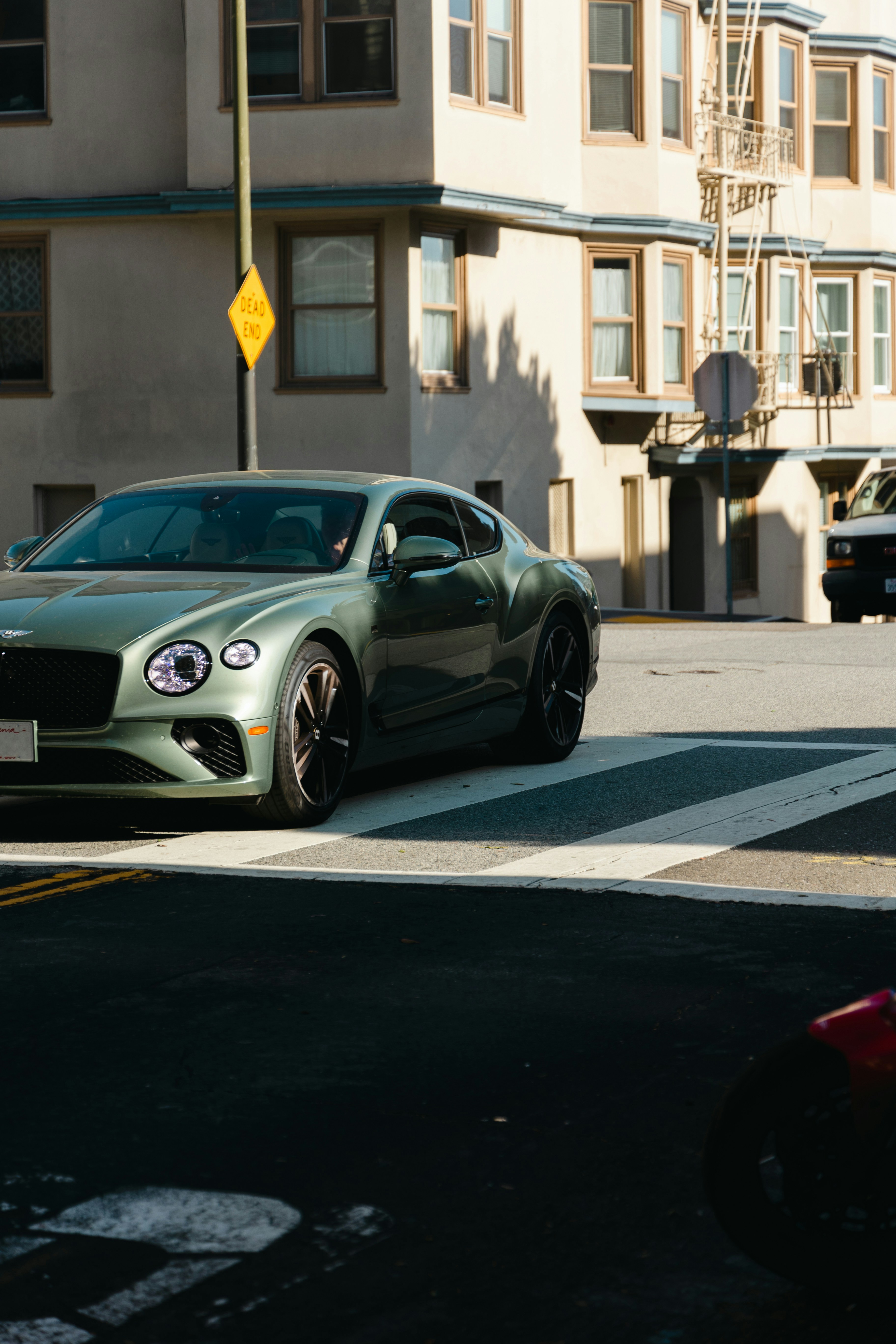 Green Bentley Idle by a Sunlit San Francisco-Style Street