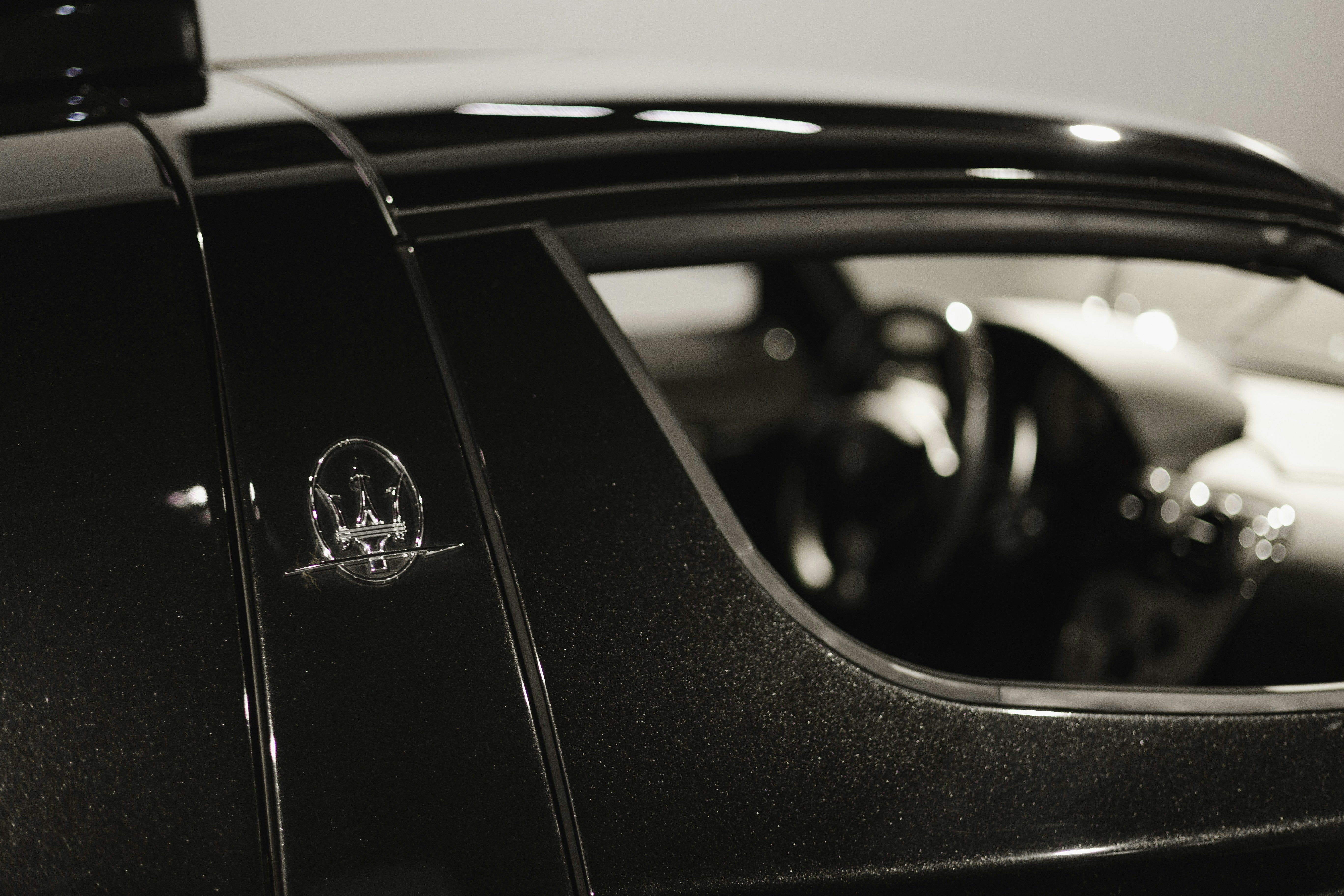 Midnight Glint: Maserati Badge on a Velvet Black Silhouette