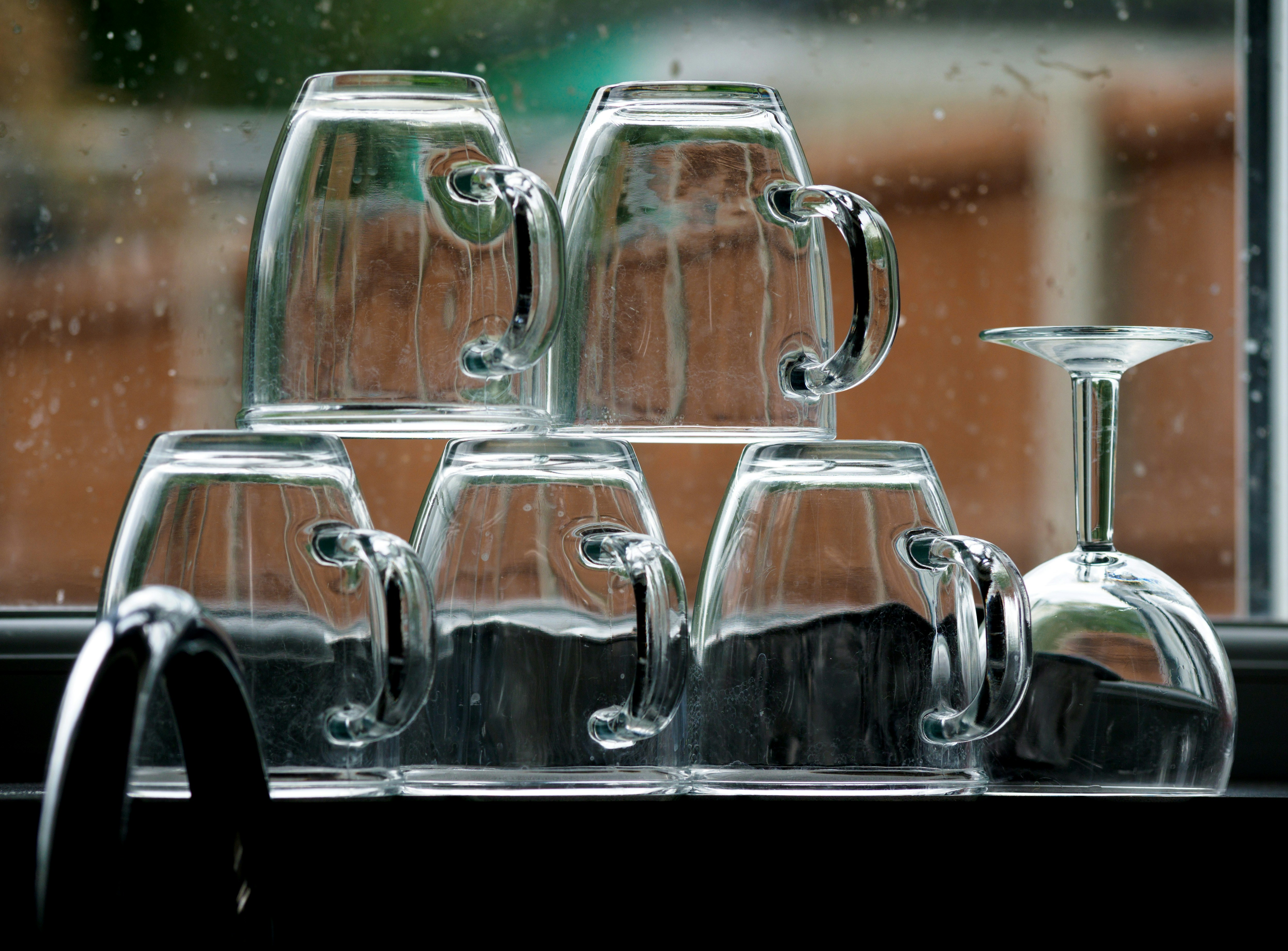A group of glass cups sitting on top of a window sill photo – Free Grey ...