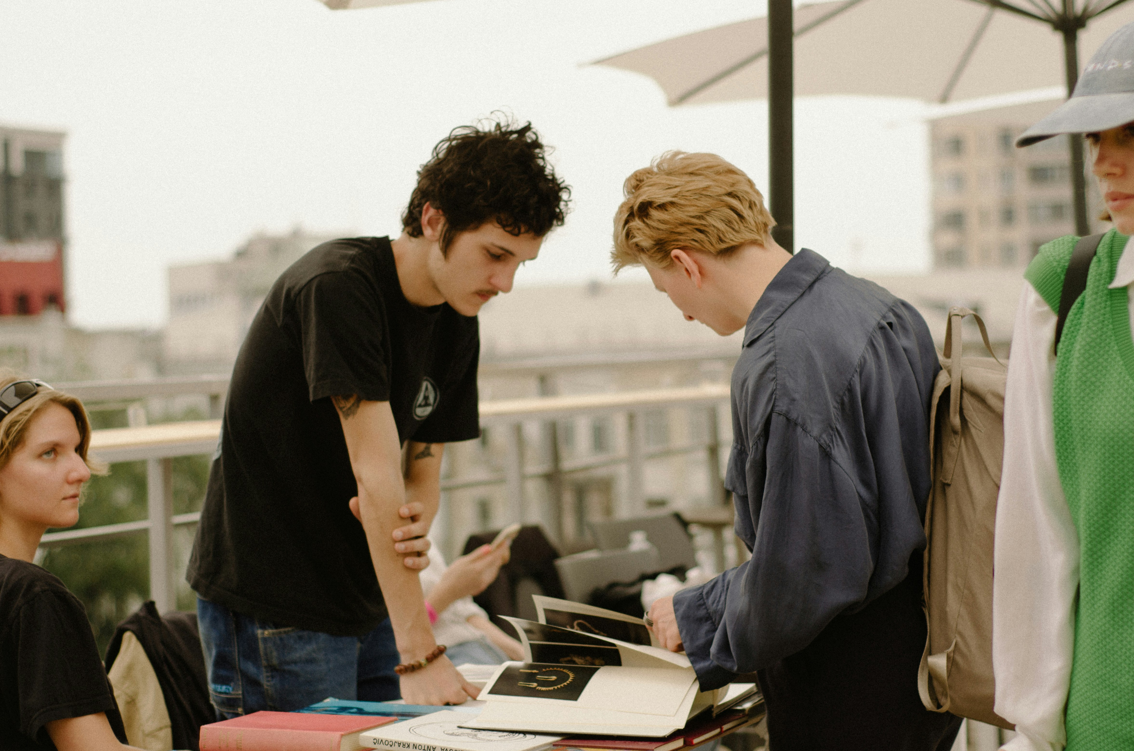A group of young men standing around a table photo – Free People ...