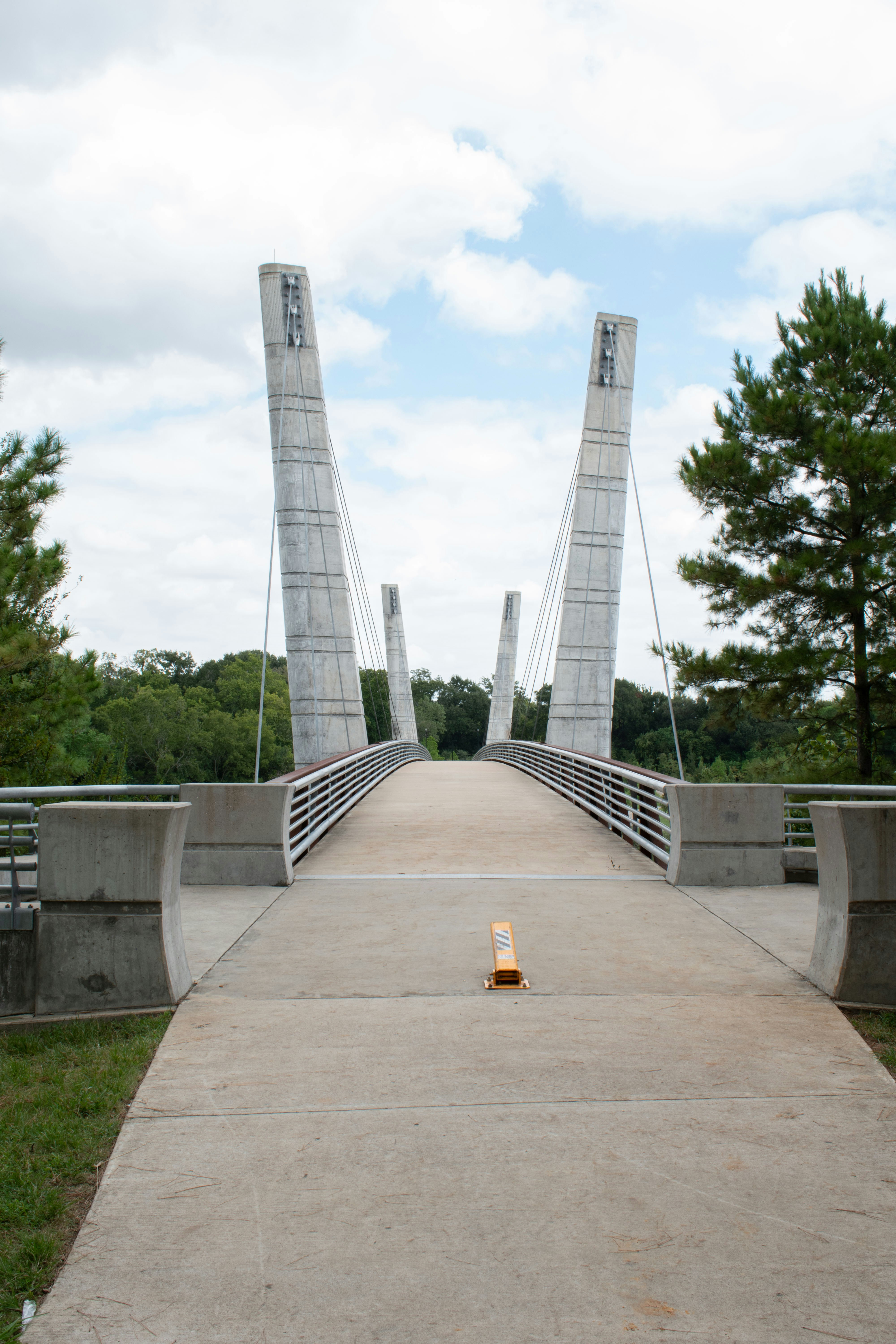 A yellow fire hydrant sitting on the side of a bridge photo – Free ...