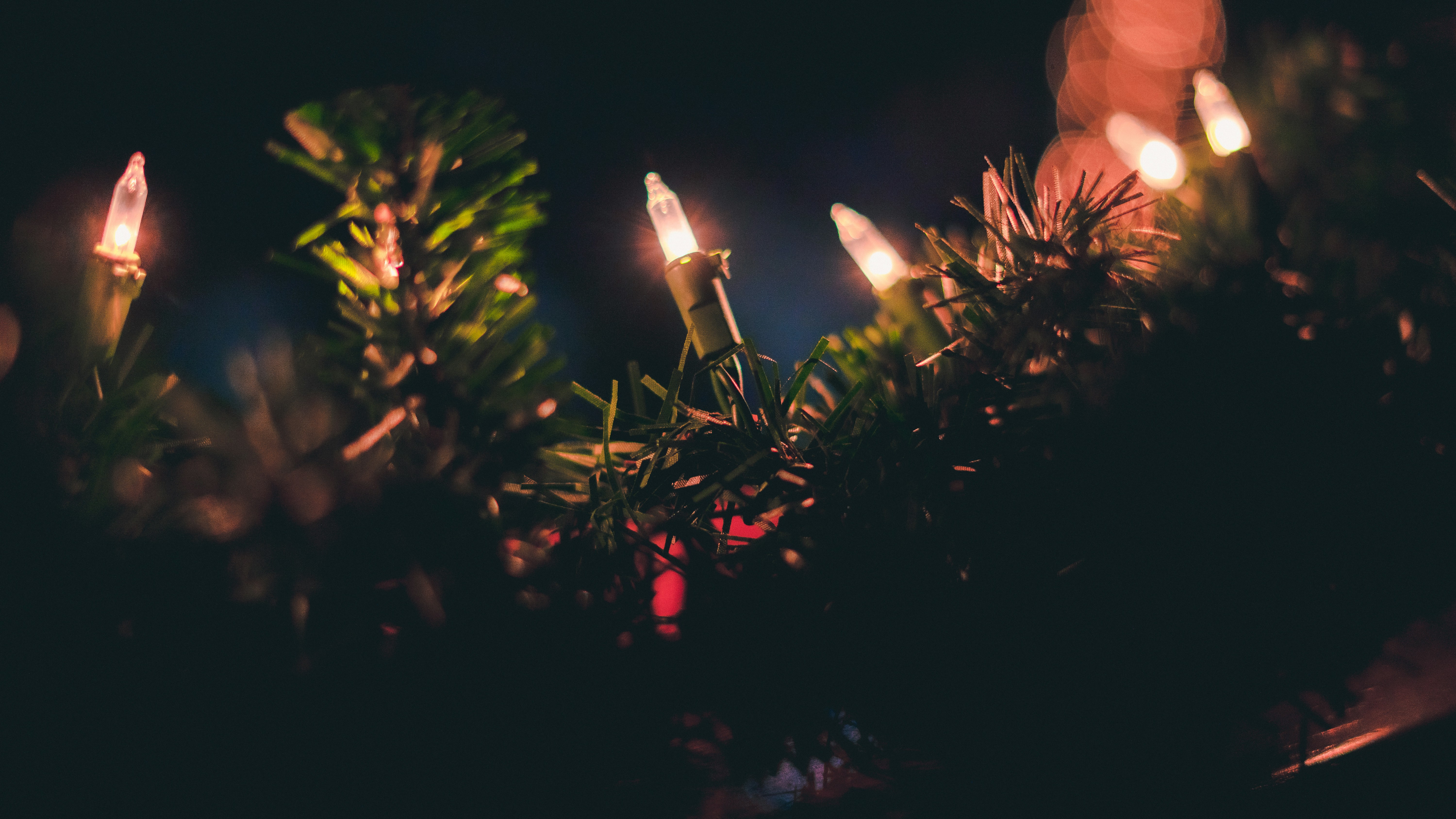 Flickering candles casting a warm glow over a darkened table setting.