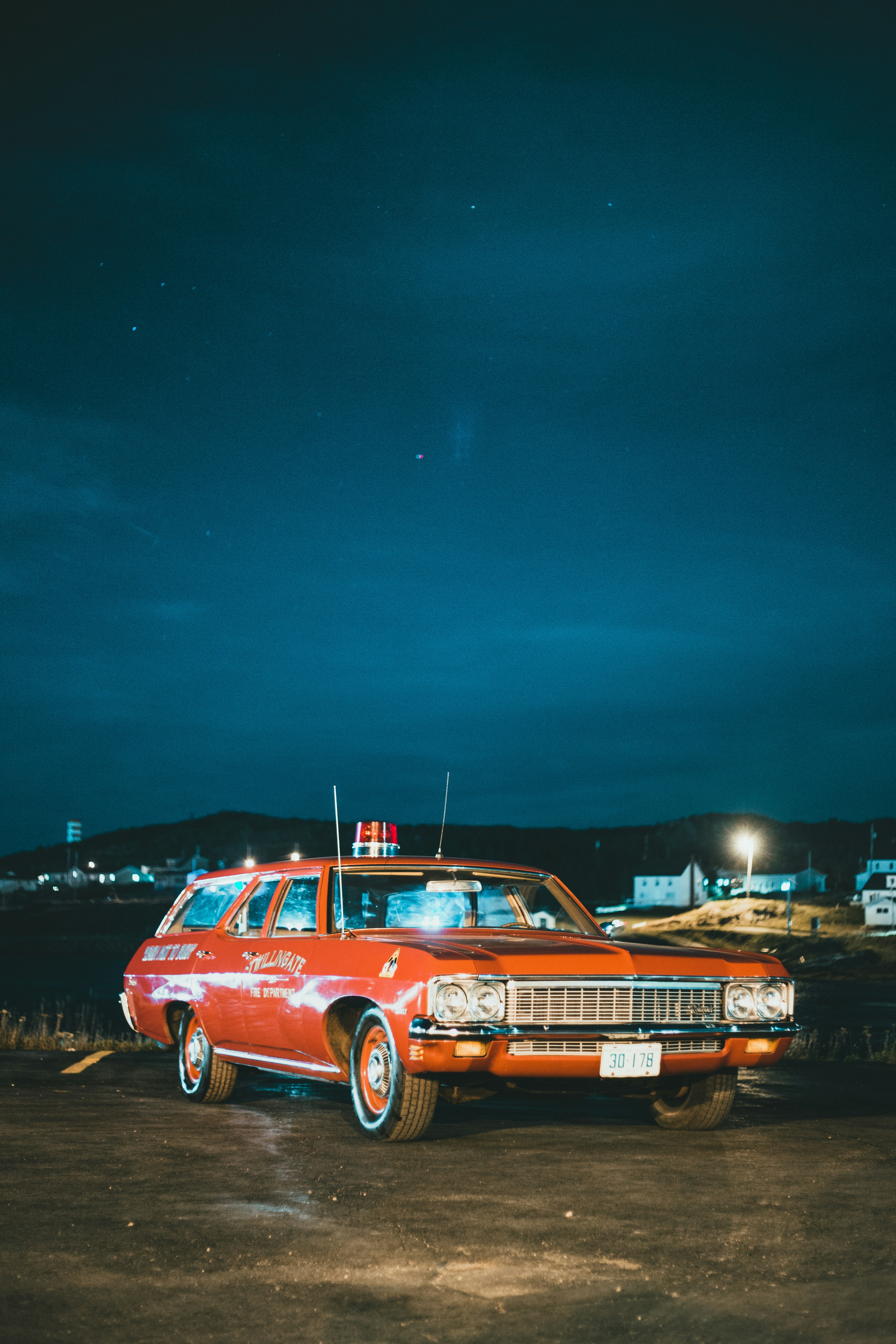 a red car parked in a parking lot at night