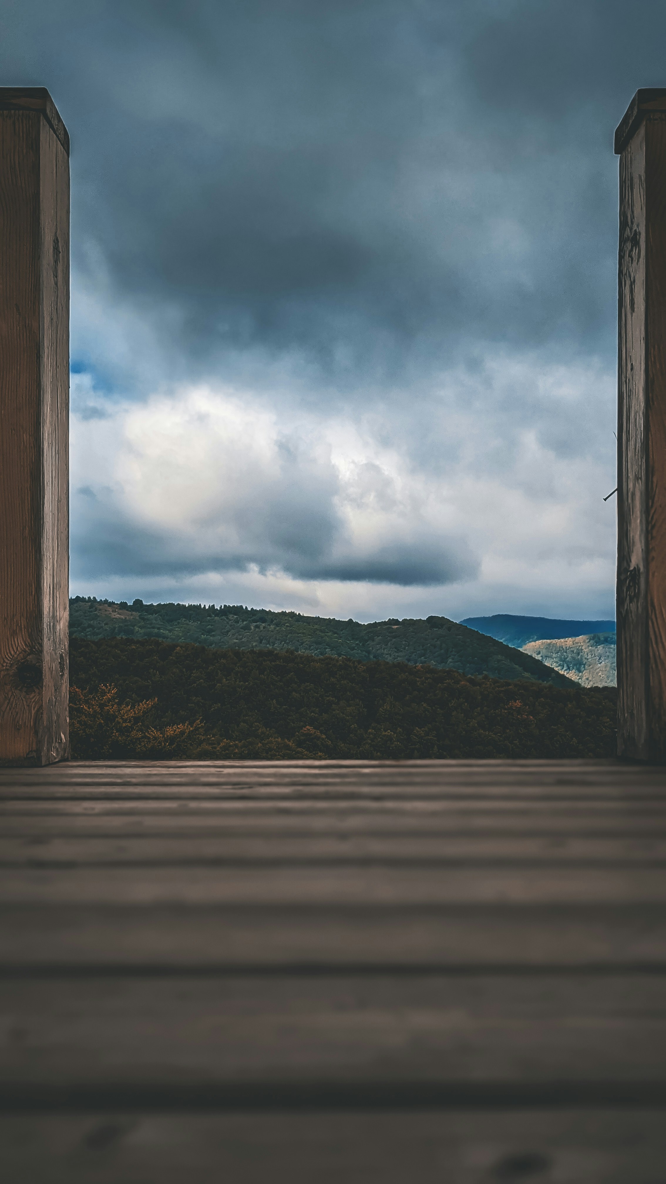 Horizon Framed: A Wooden Corridor to Cloud and Ridge