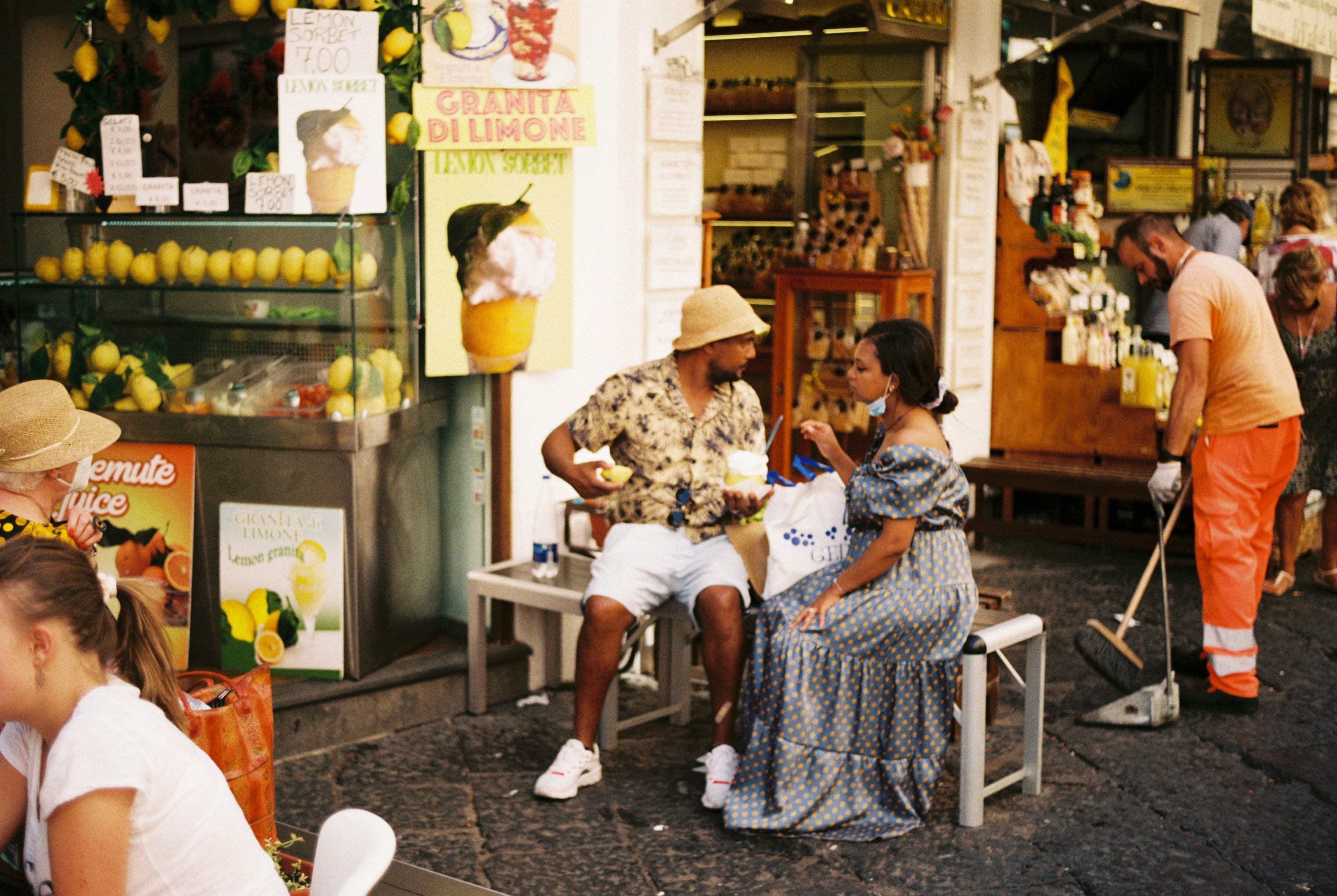 Benchside Market Moment: A Couple in Conversation Amid Lemon Stalls
