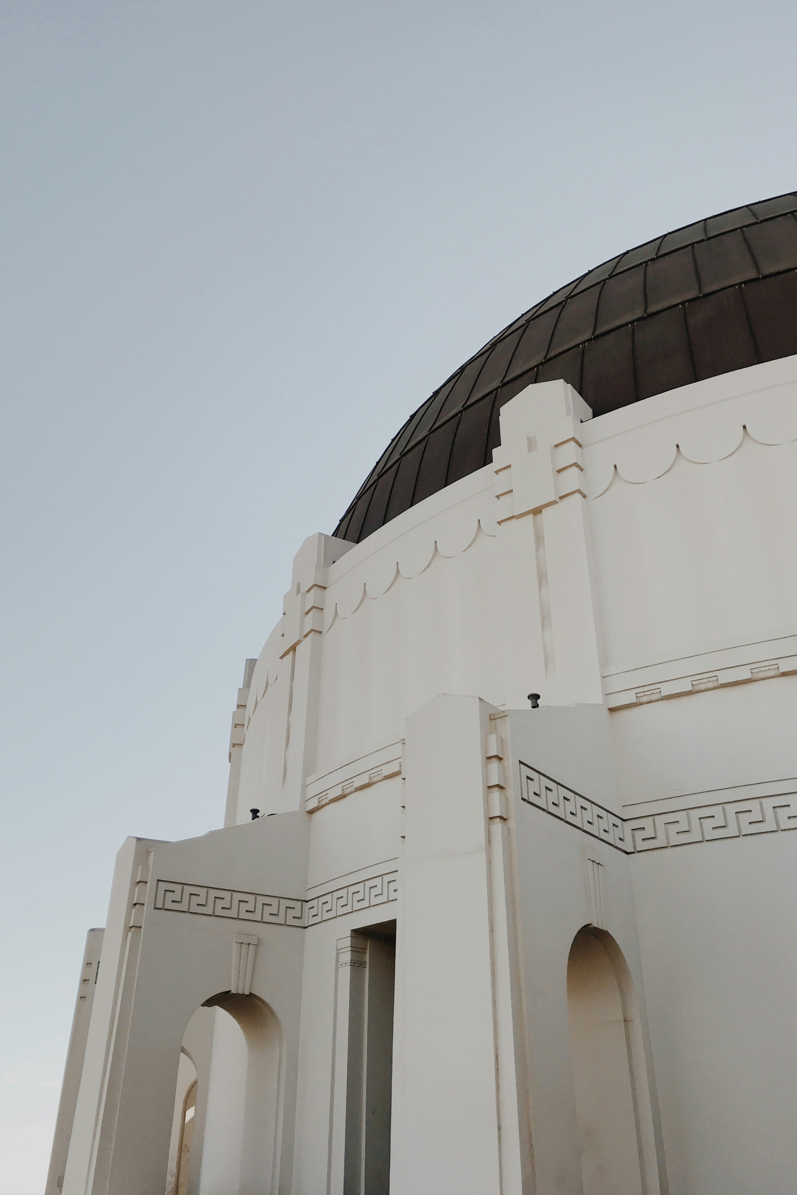 A close-up view of a white observatory structure with a prominent dome, showcasing intricate architectural details against a clear sky.