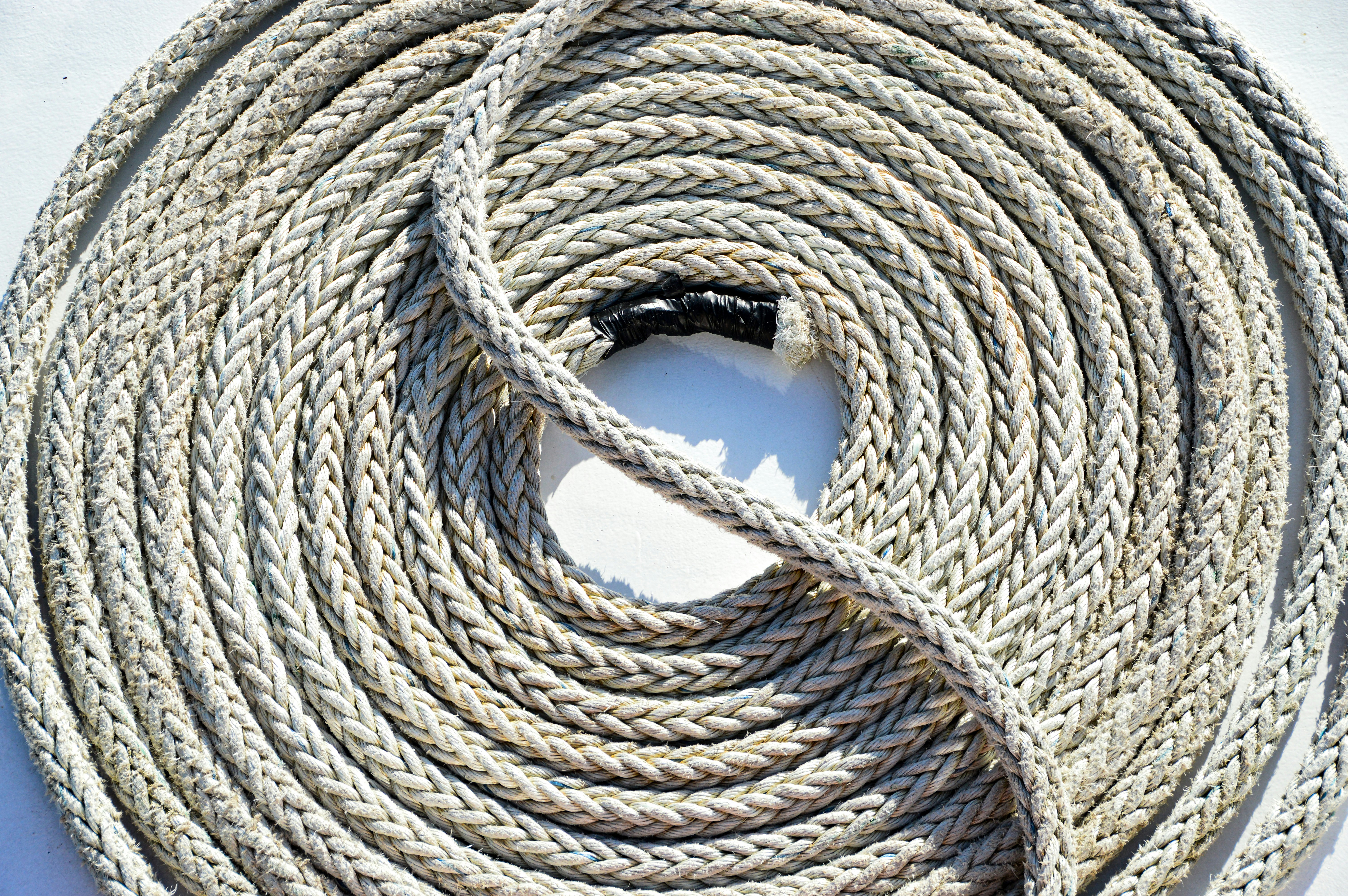 Rope coil on deck | a close up of a rope on a white surface