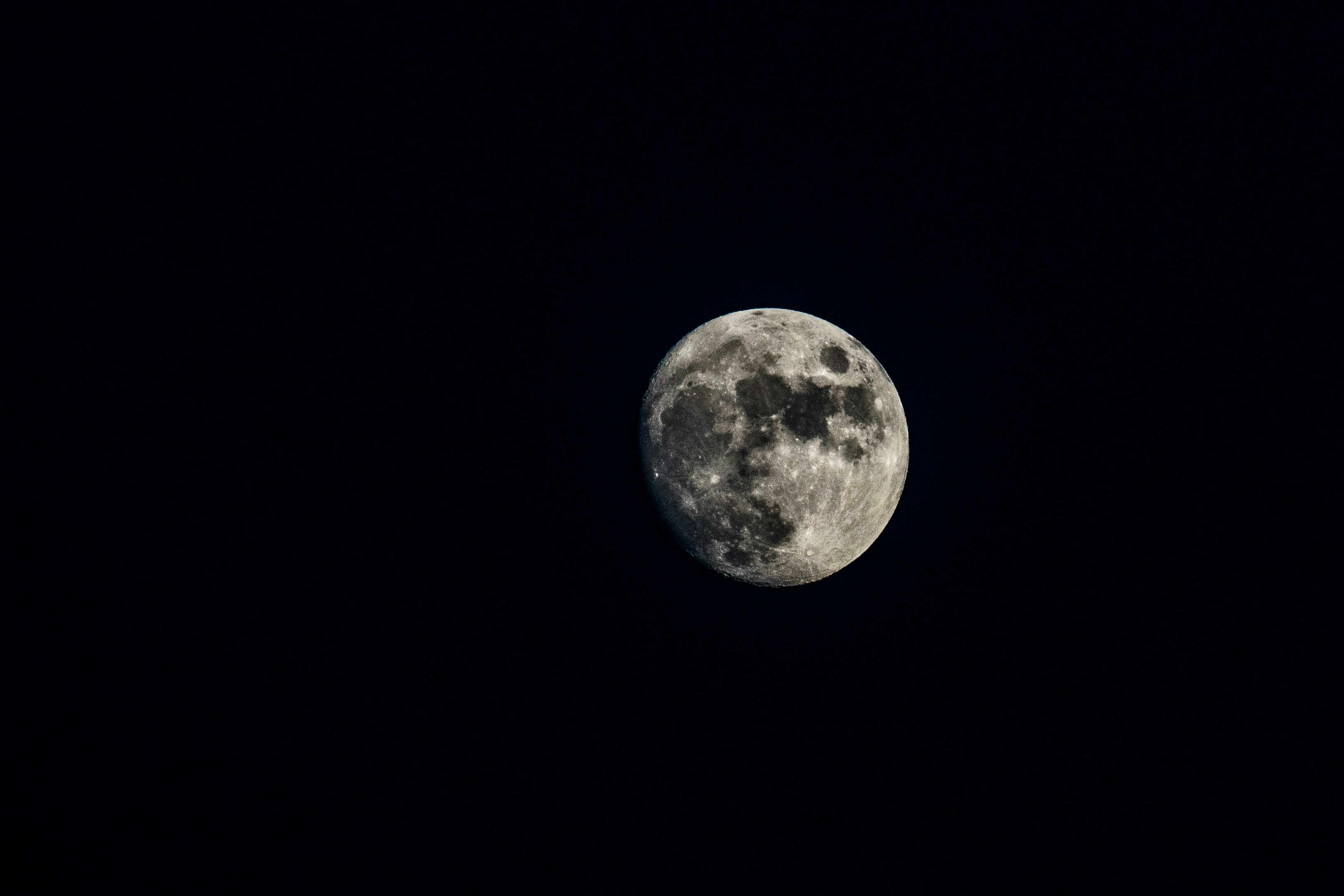 Full moon against a dark night sky, displaying detailed lunar surface features.