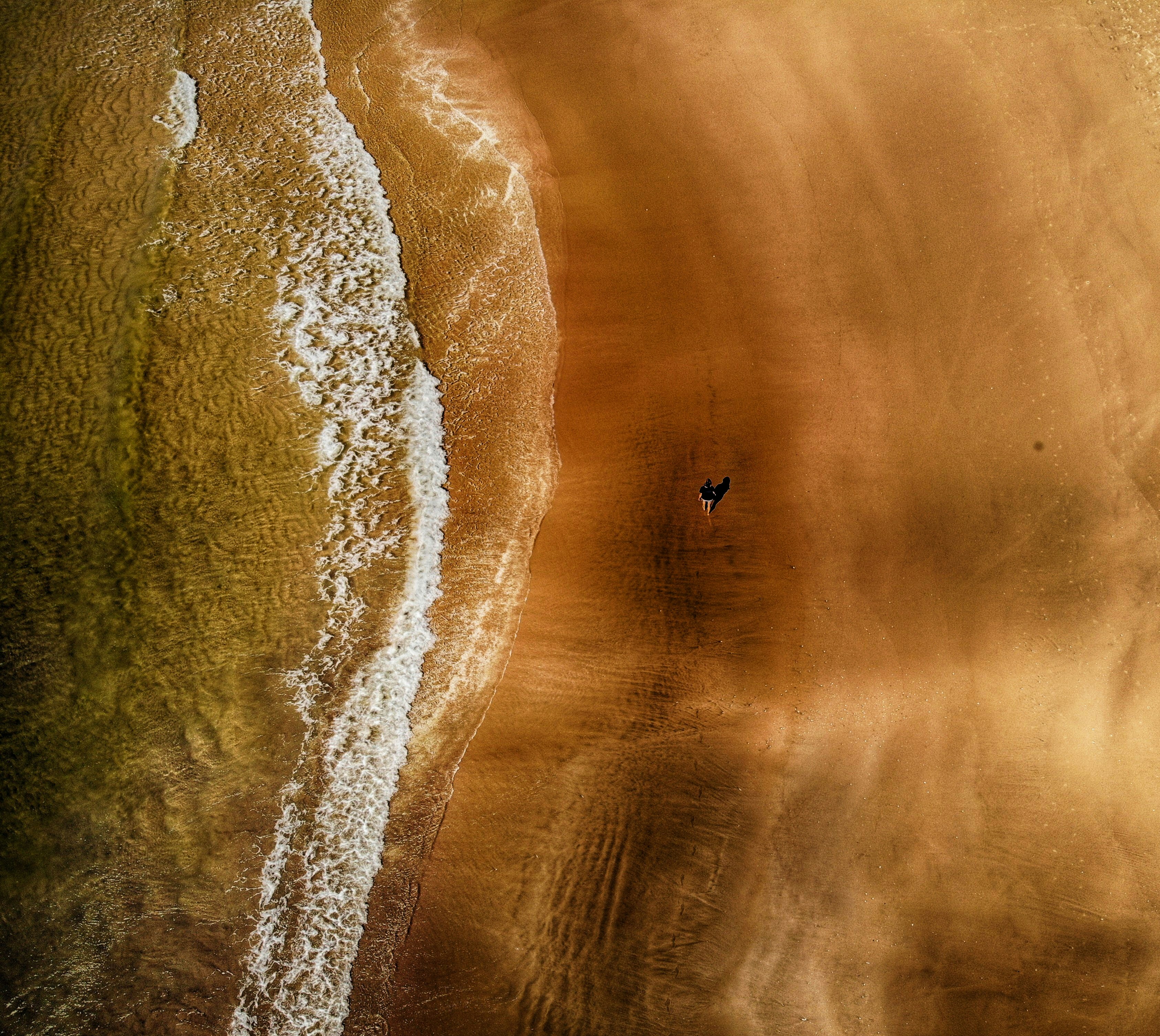 Solitary Figure on a Burnished Shore, Captured from Above