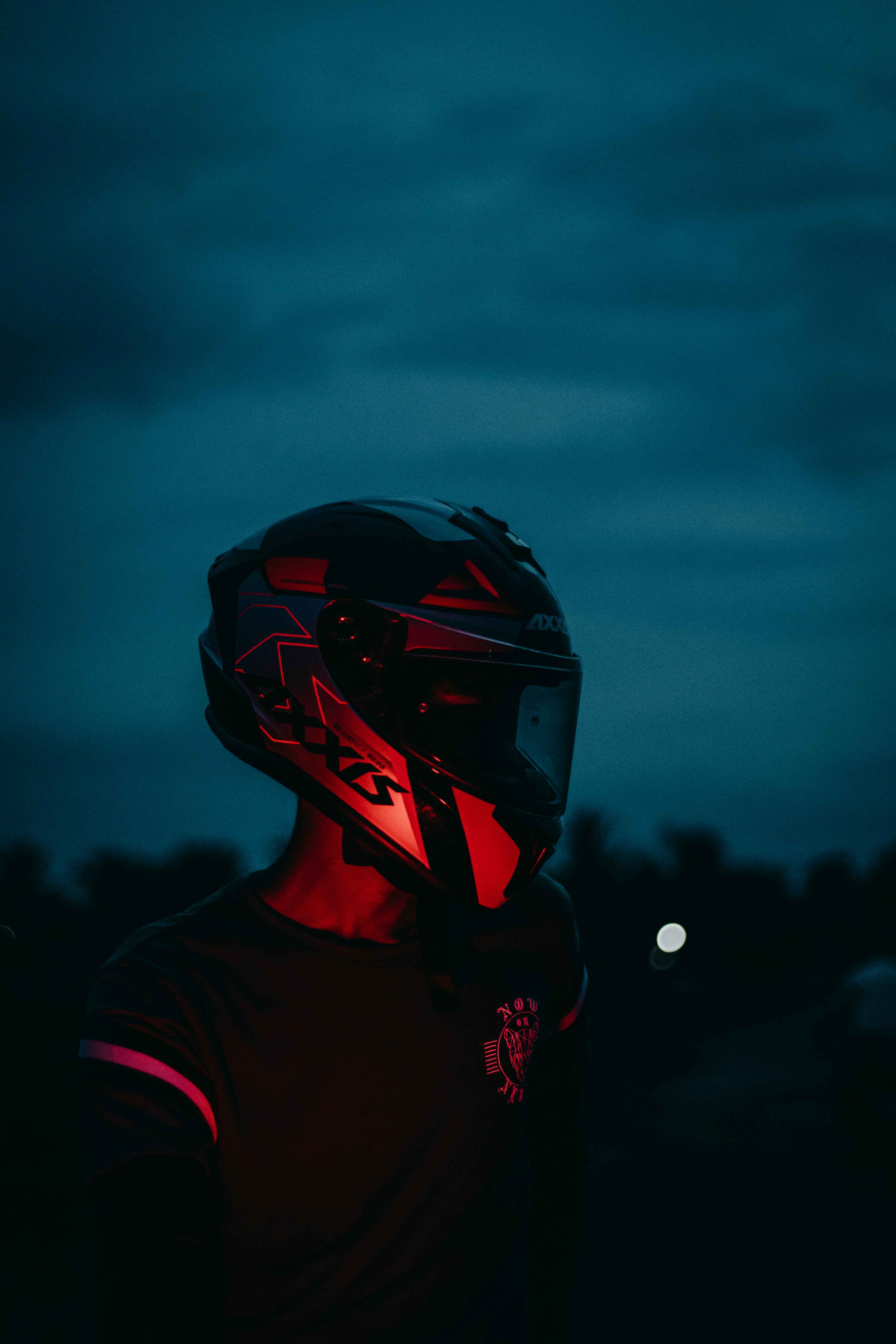 Neon-Red Helm in Twilight: A Lone Rider Beneath a Cobalt Dusk