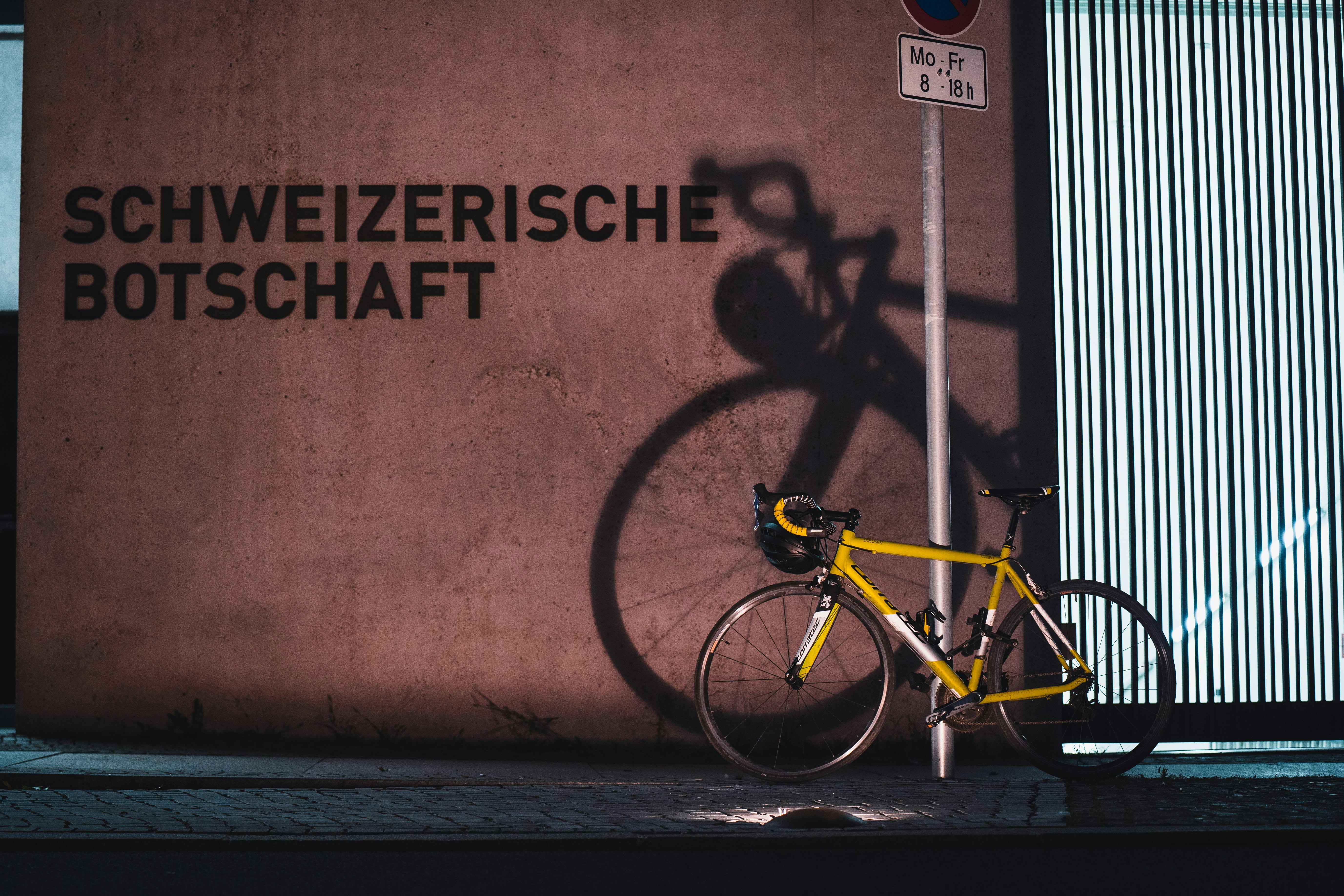 Dusk-lit Yellow Bicycle Leaning by the Swiss Embassy Wall