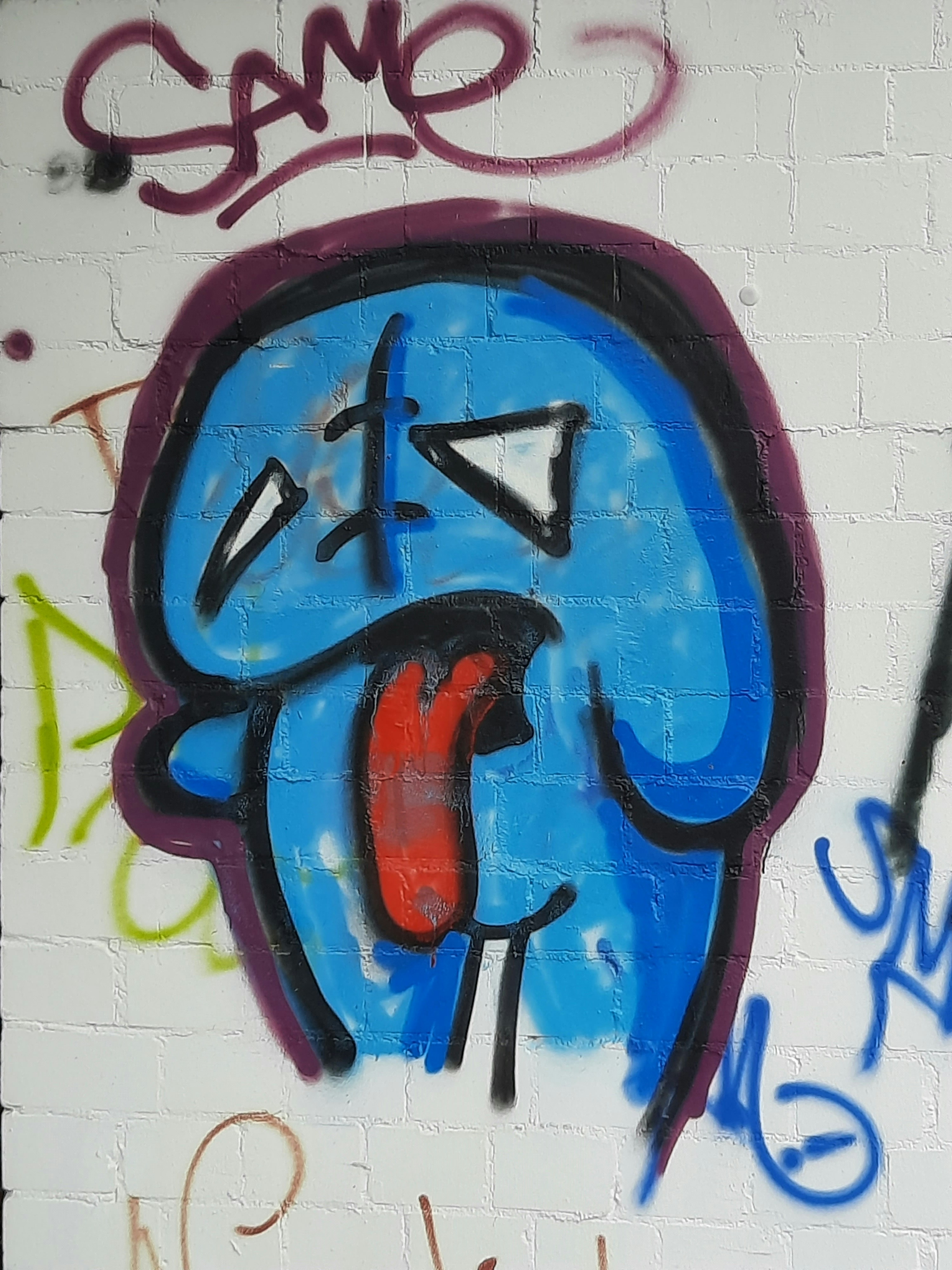 Graffiti on a white brick wall with a blue face photo – Free Graphity ...