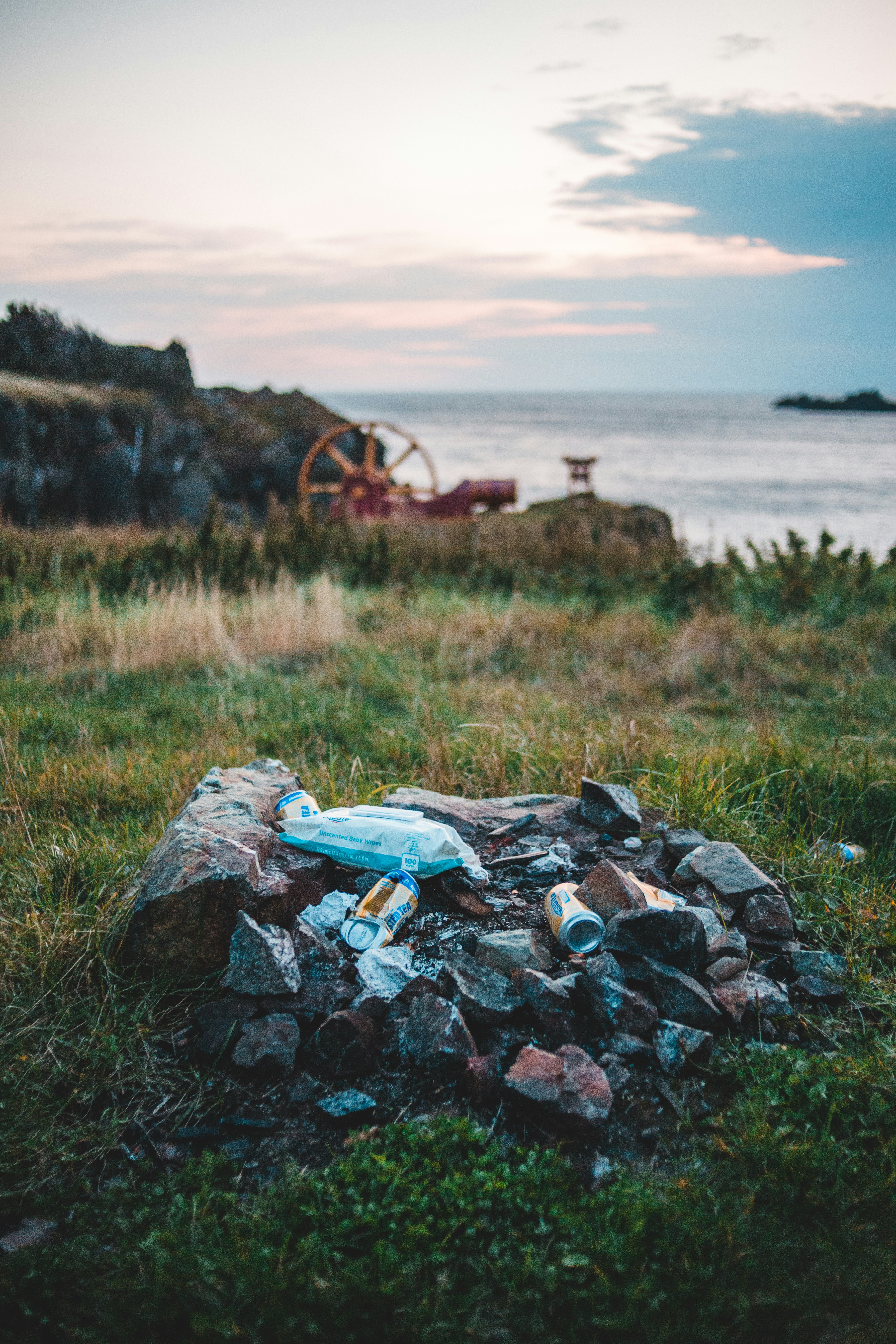 A pile of trash sitting on top of a lush green field photo – Free ...