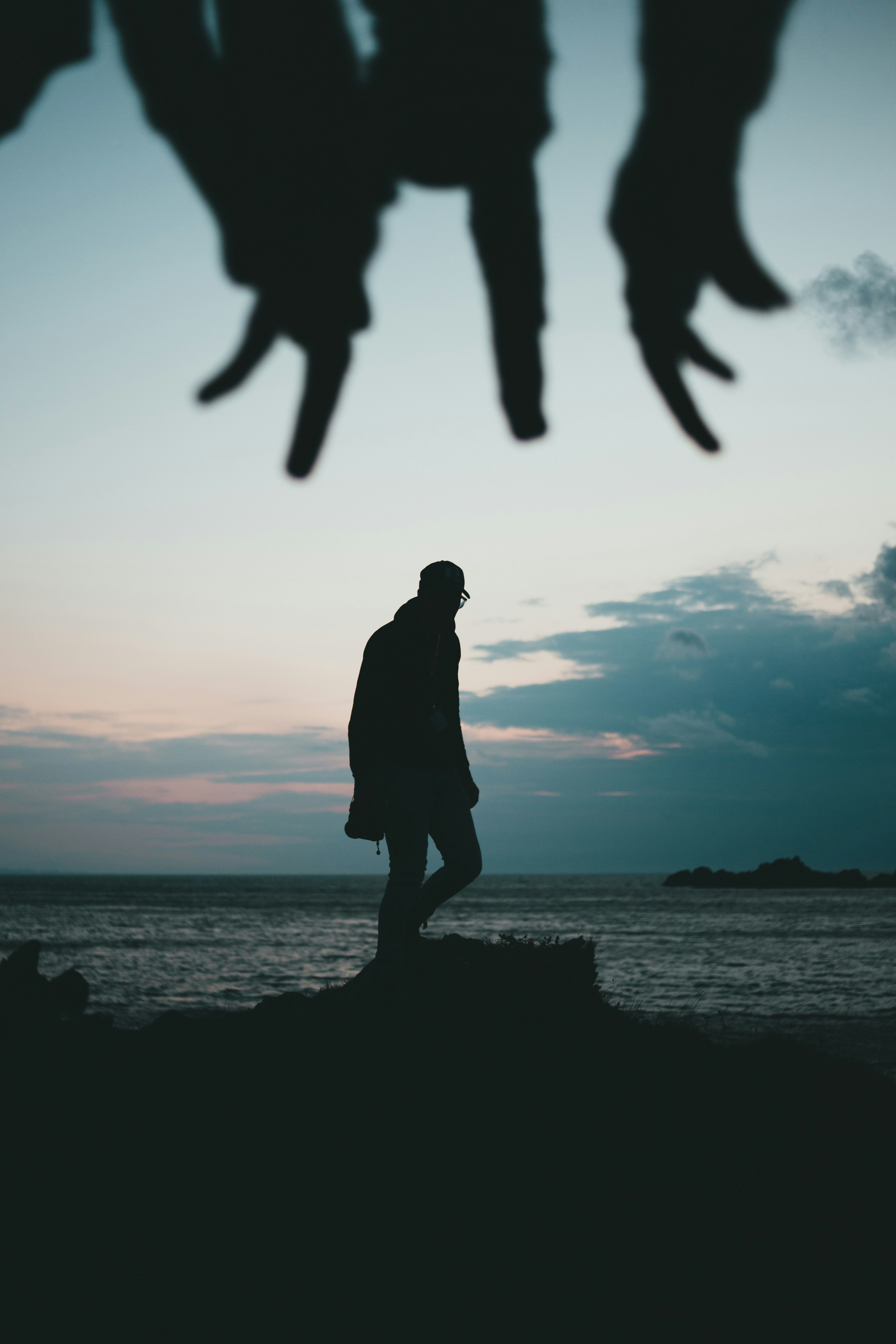 Silhouette on the Edge: A lone figure against a dusk sea