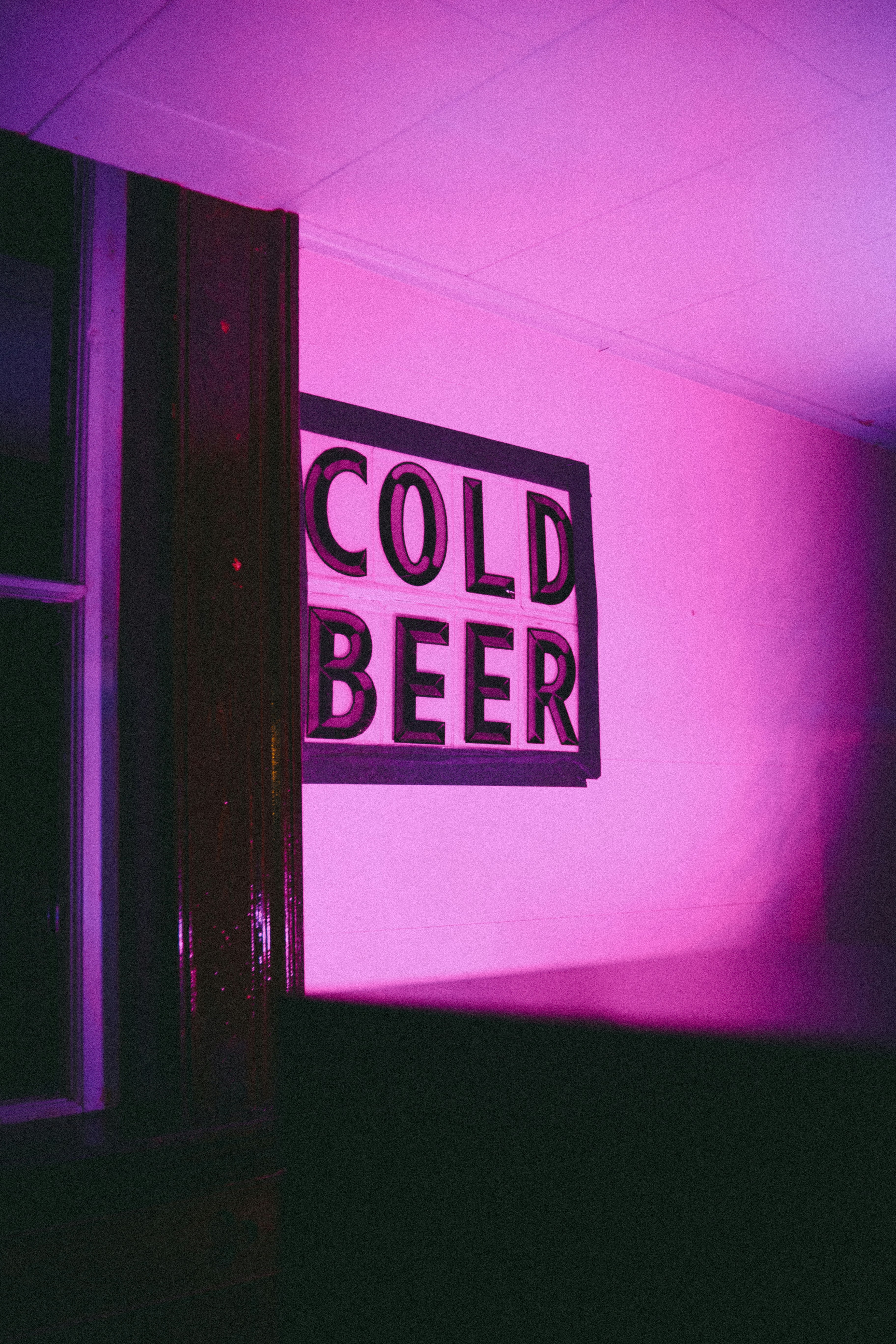 a sign that reads cold beer on a wall