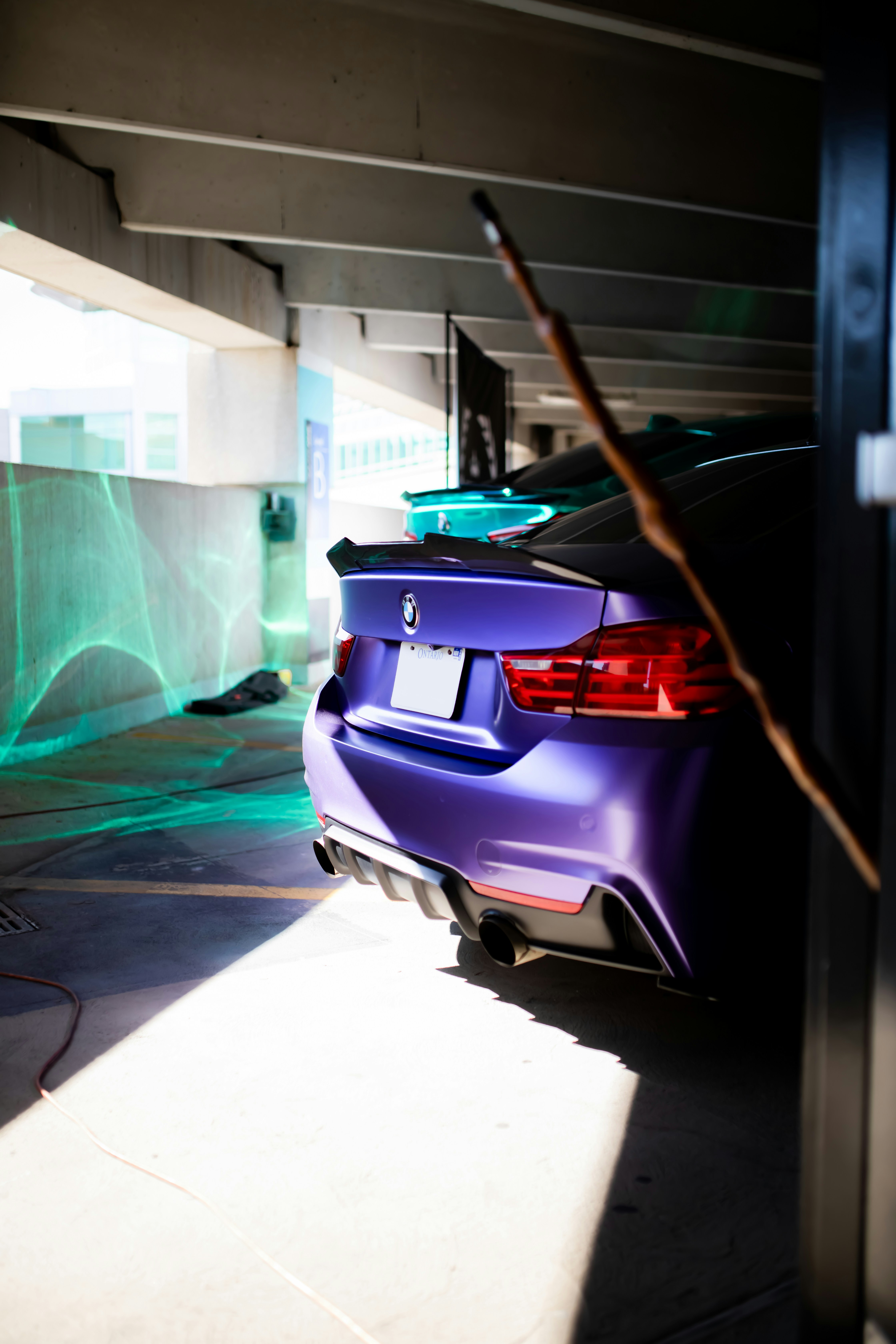 Matte Violet BMW in a Dim Parking Garage, Sunlit Curves and Neon Accents