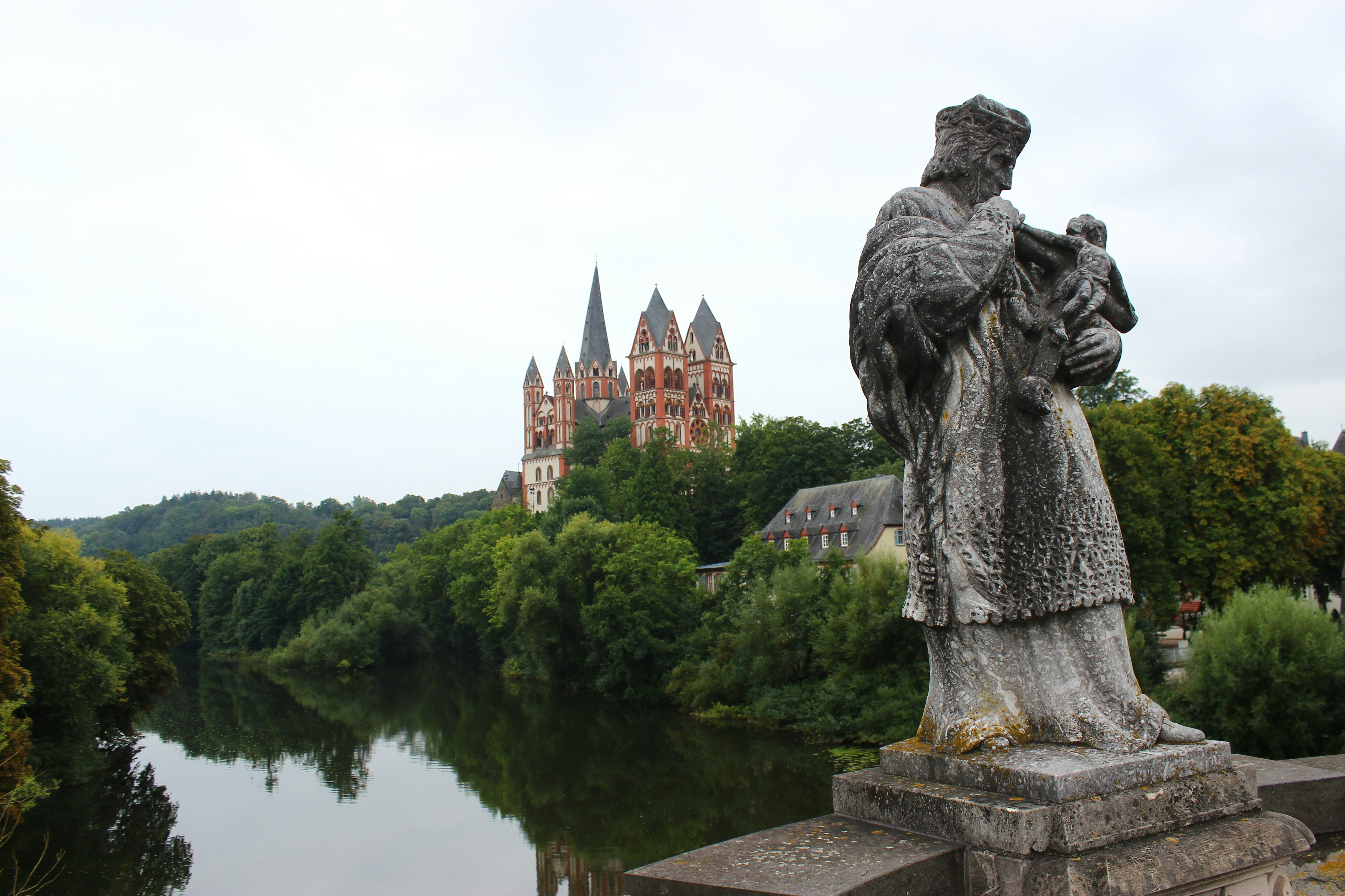 Stone Guardian on the Bridge: A Gothic Cathedral Looms Across the River