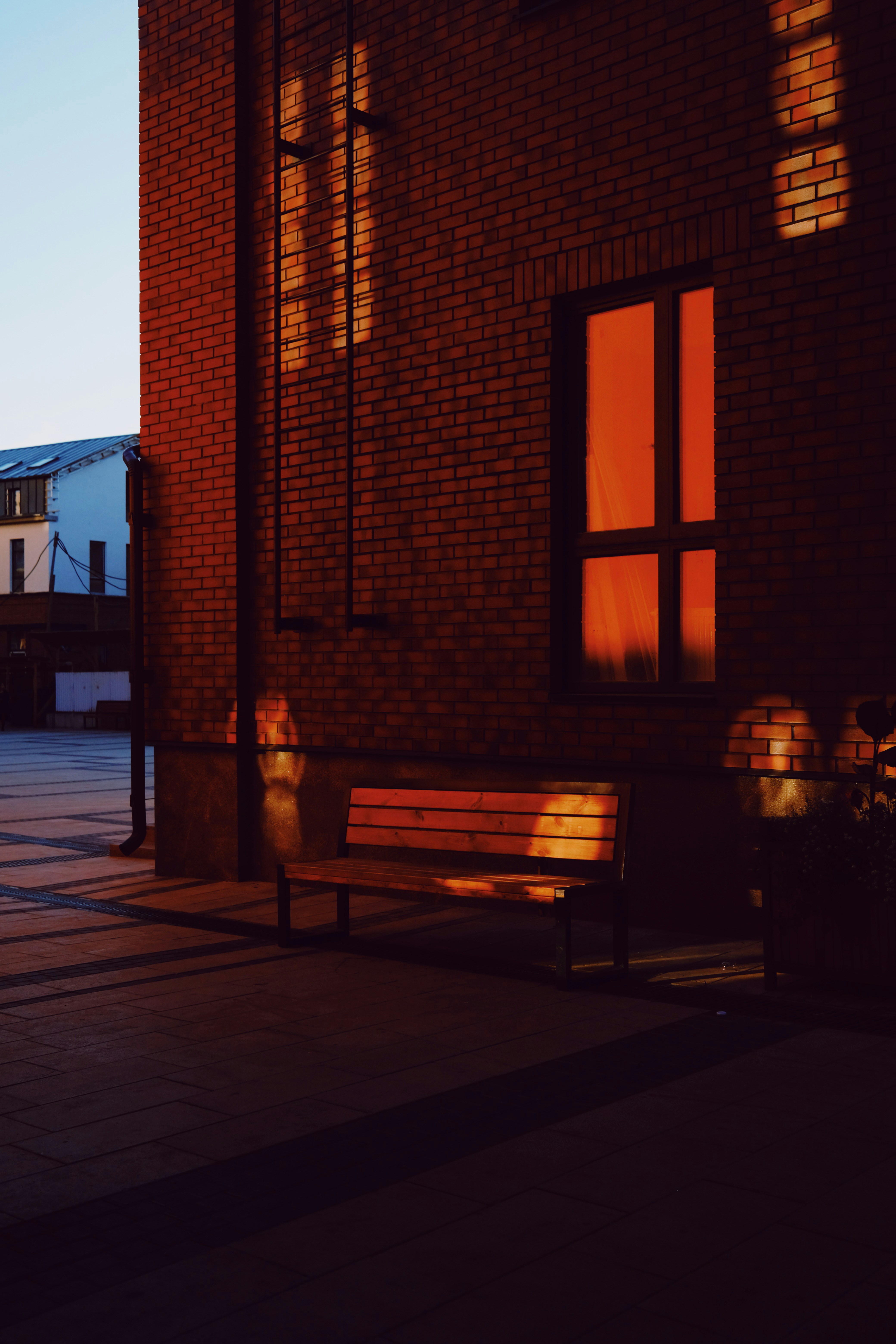 Dusk Ember: A Quiet Bench beside the Orange Window