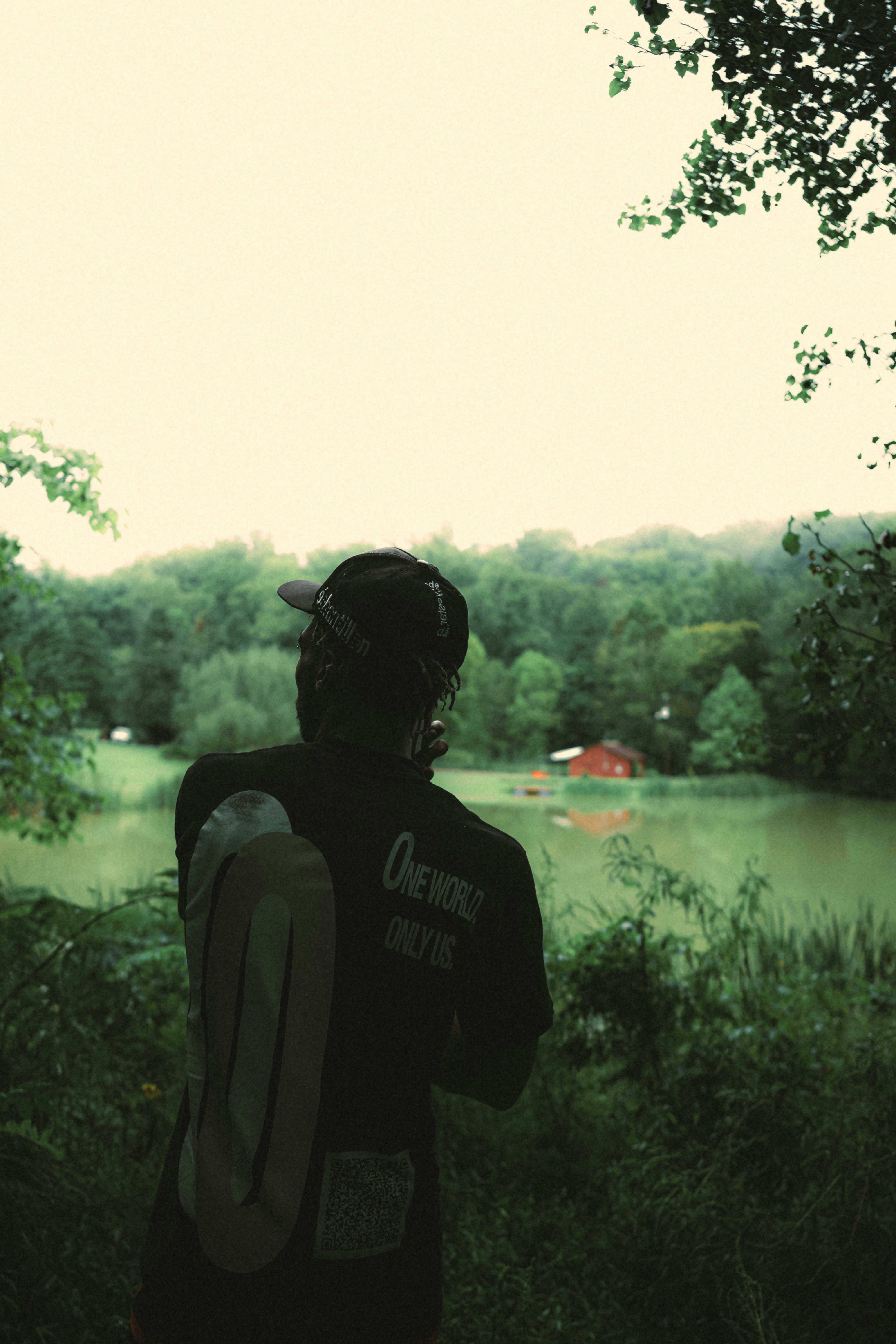 Silhouette at the Lake: A Quiet Portrait Among Green Reflections