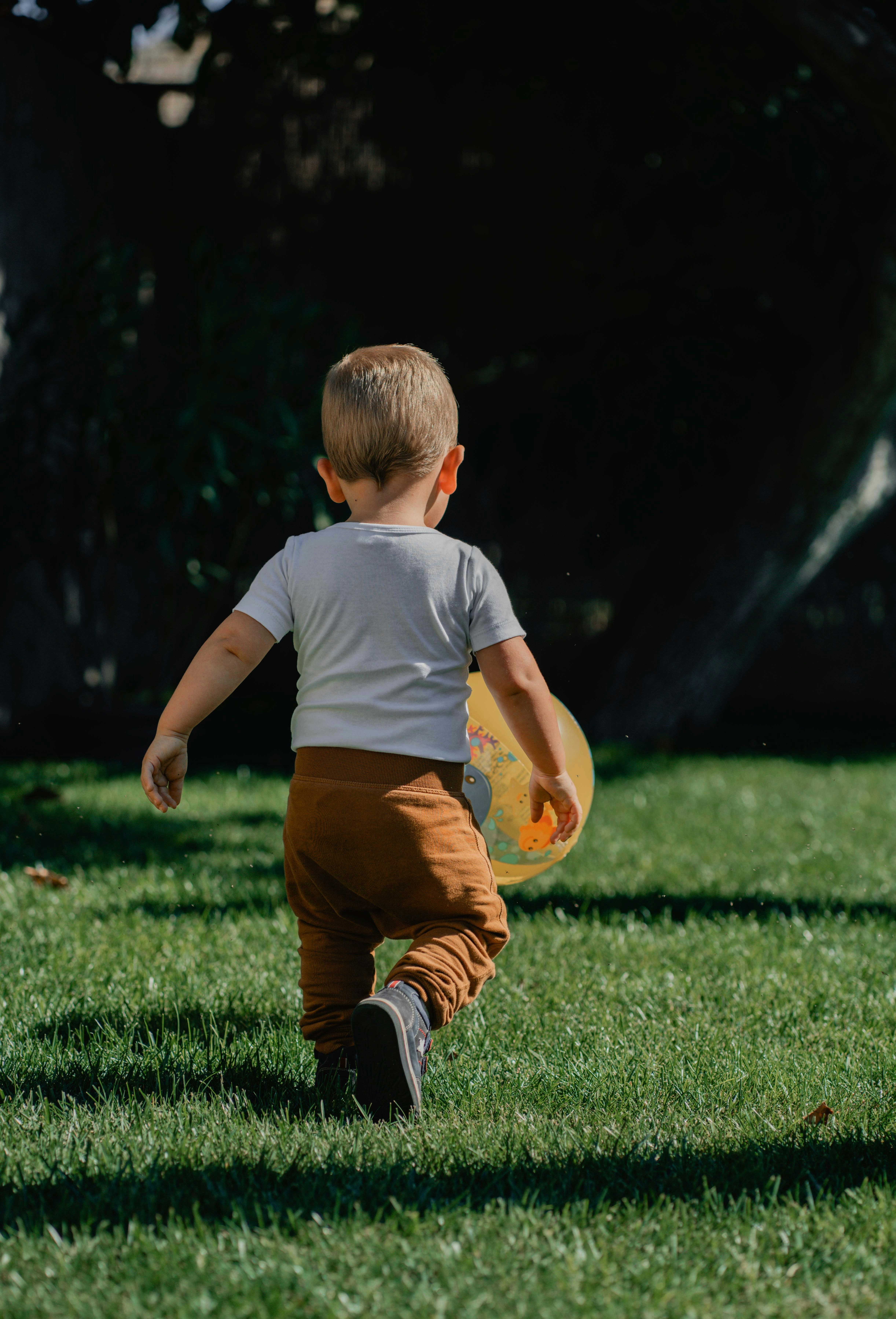 A little boy running with a frisbee in his hand photo – Free Human ...