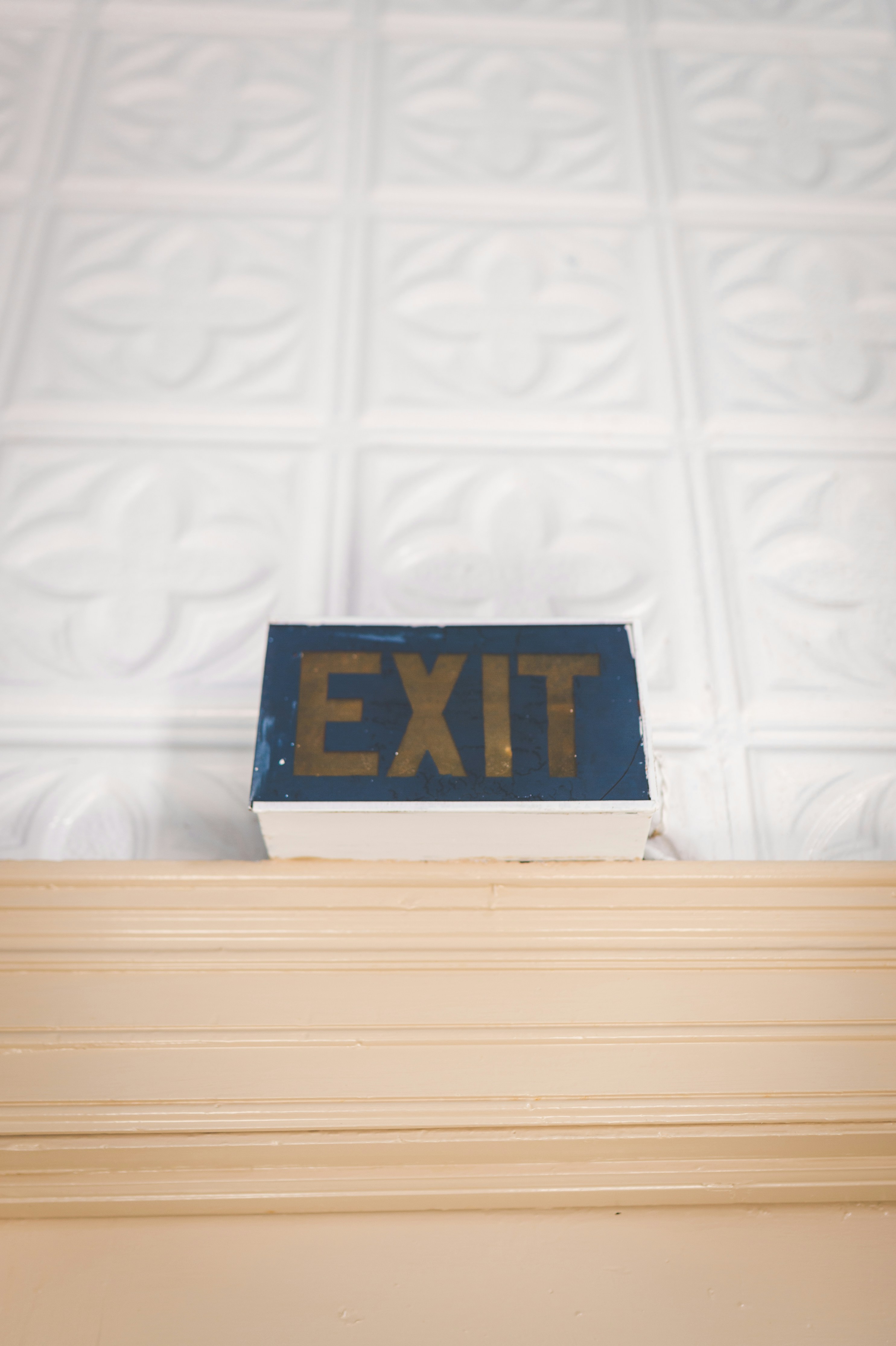 a blue exit sign sitting on top of a wooden shelf
