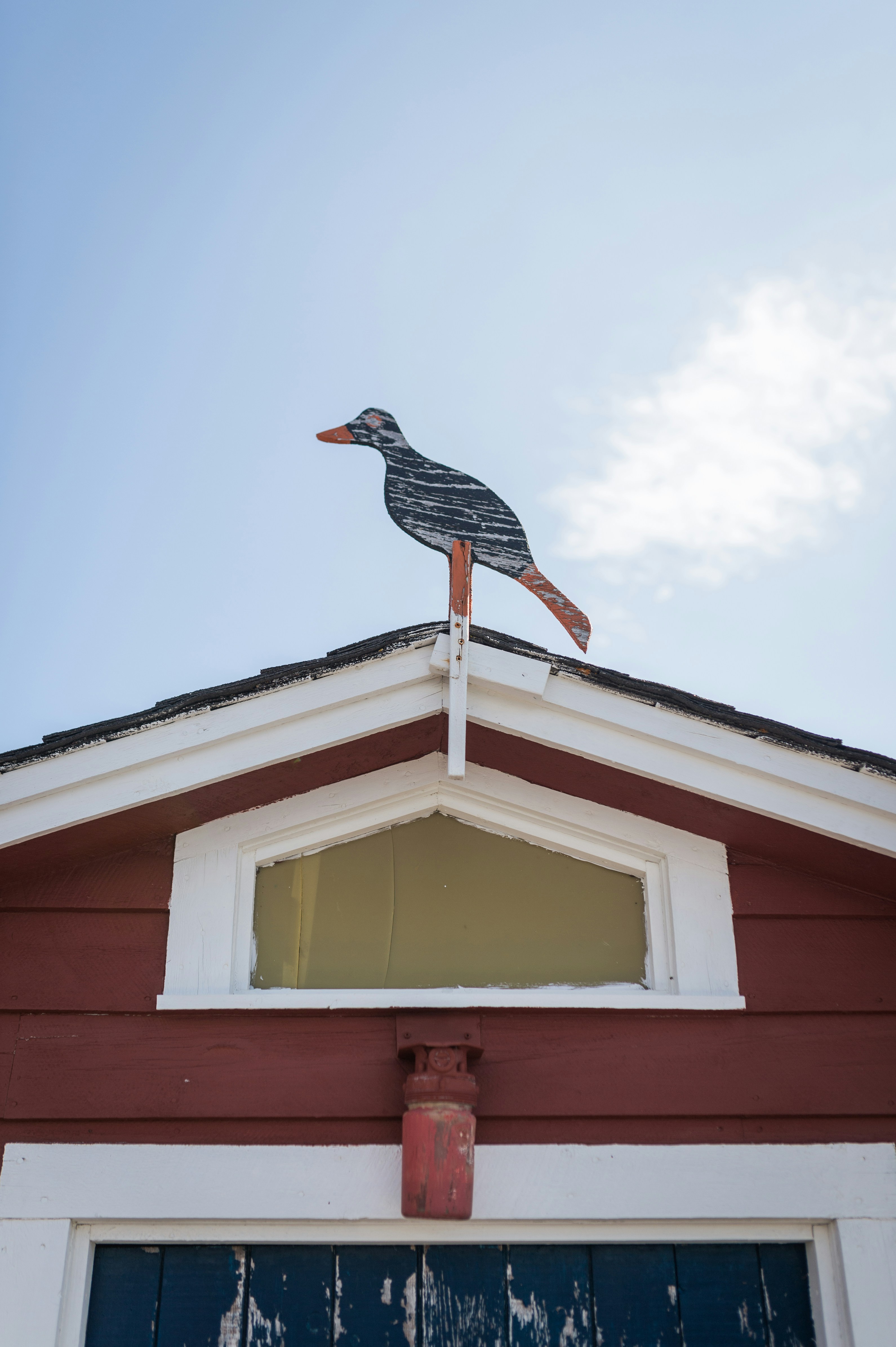 Silhouetted Weather Vane Crowns a Red Barn Under a Clear Sky