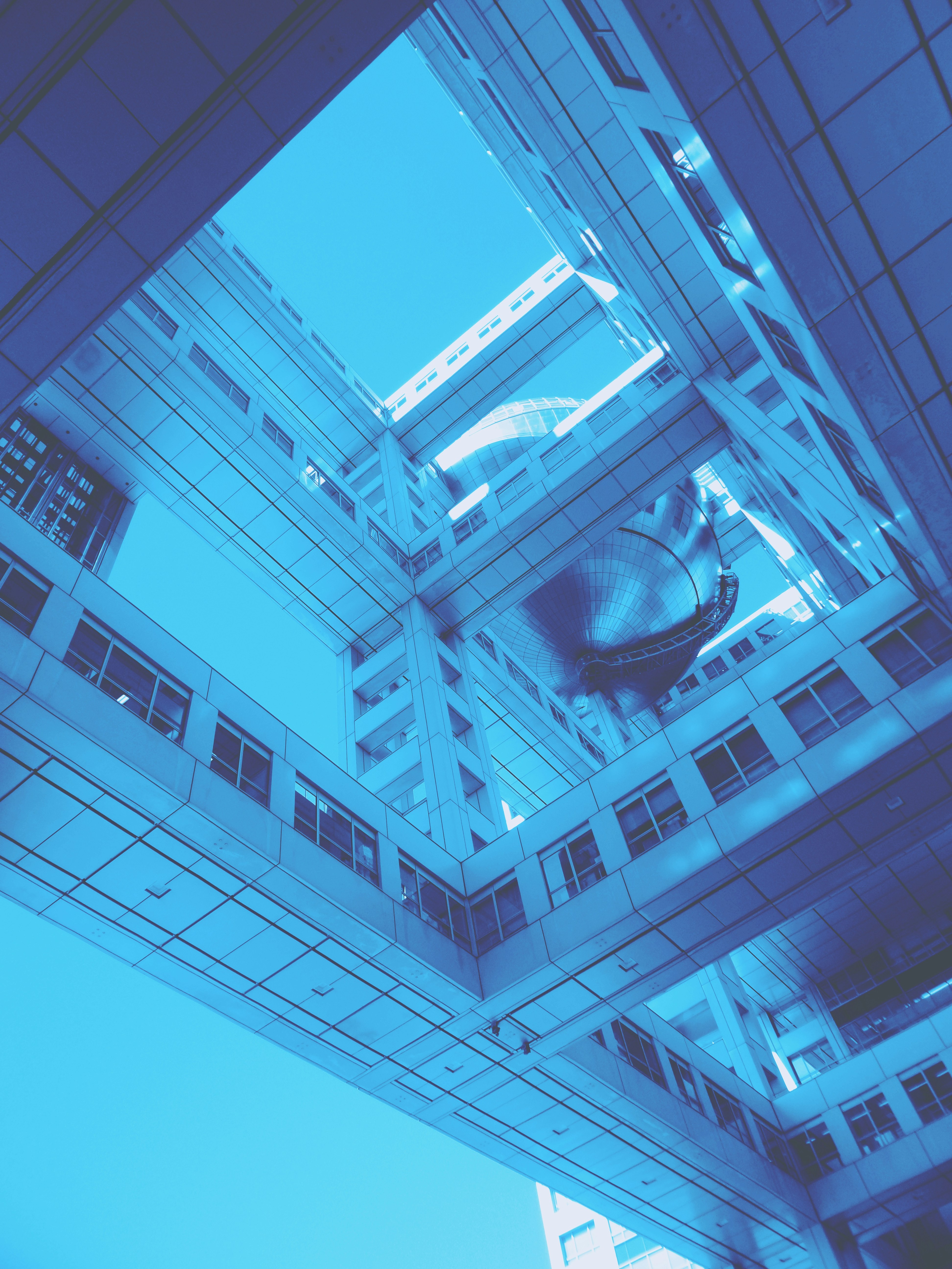 A view of a very tall building from below photo – Free Blue Image on ...