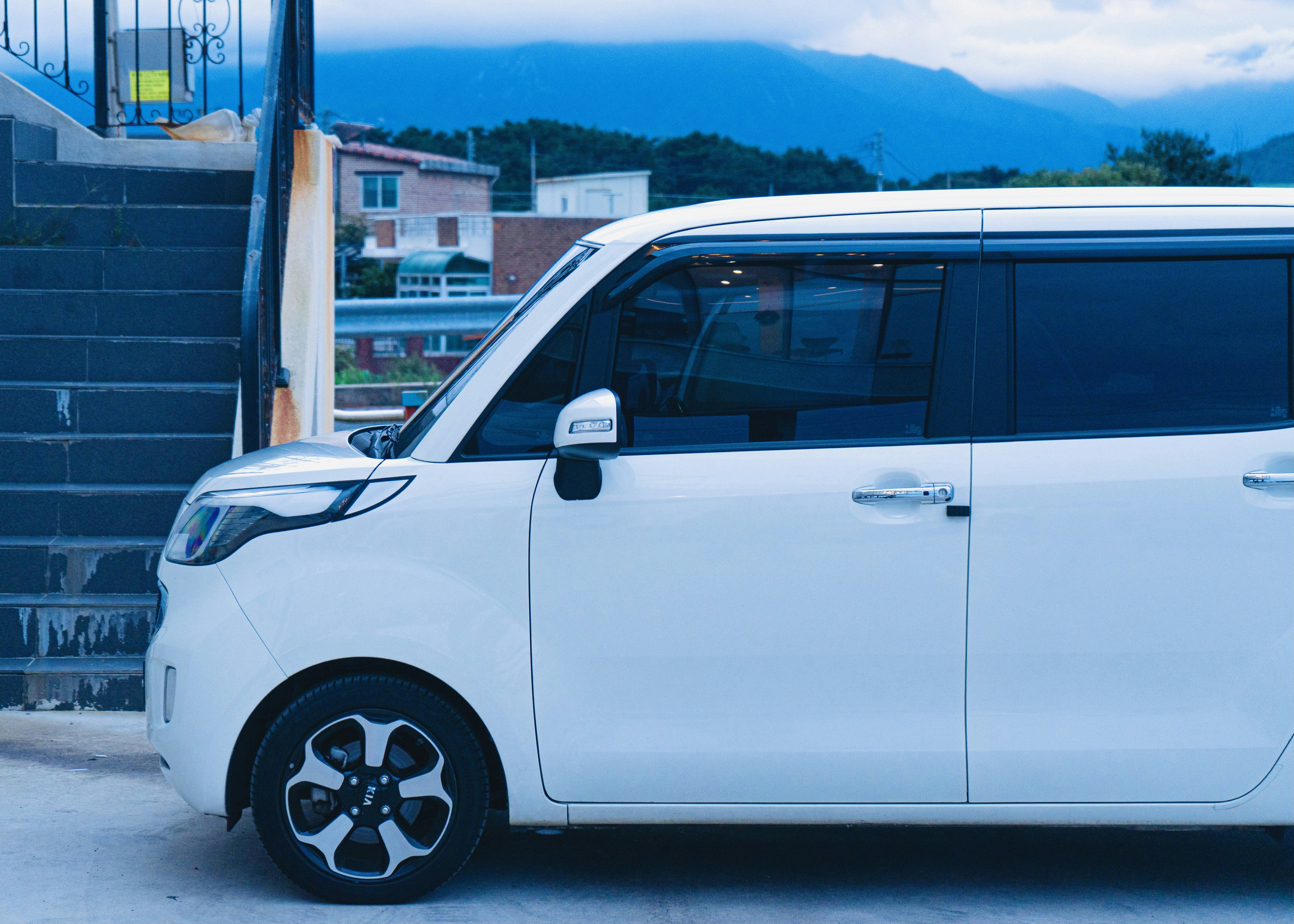 A white minivan parked in front of a building photo – Free Hello sea ...