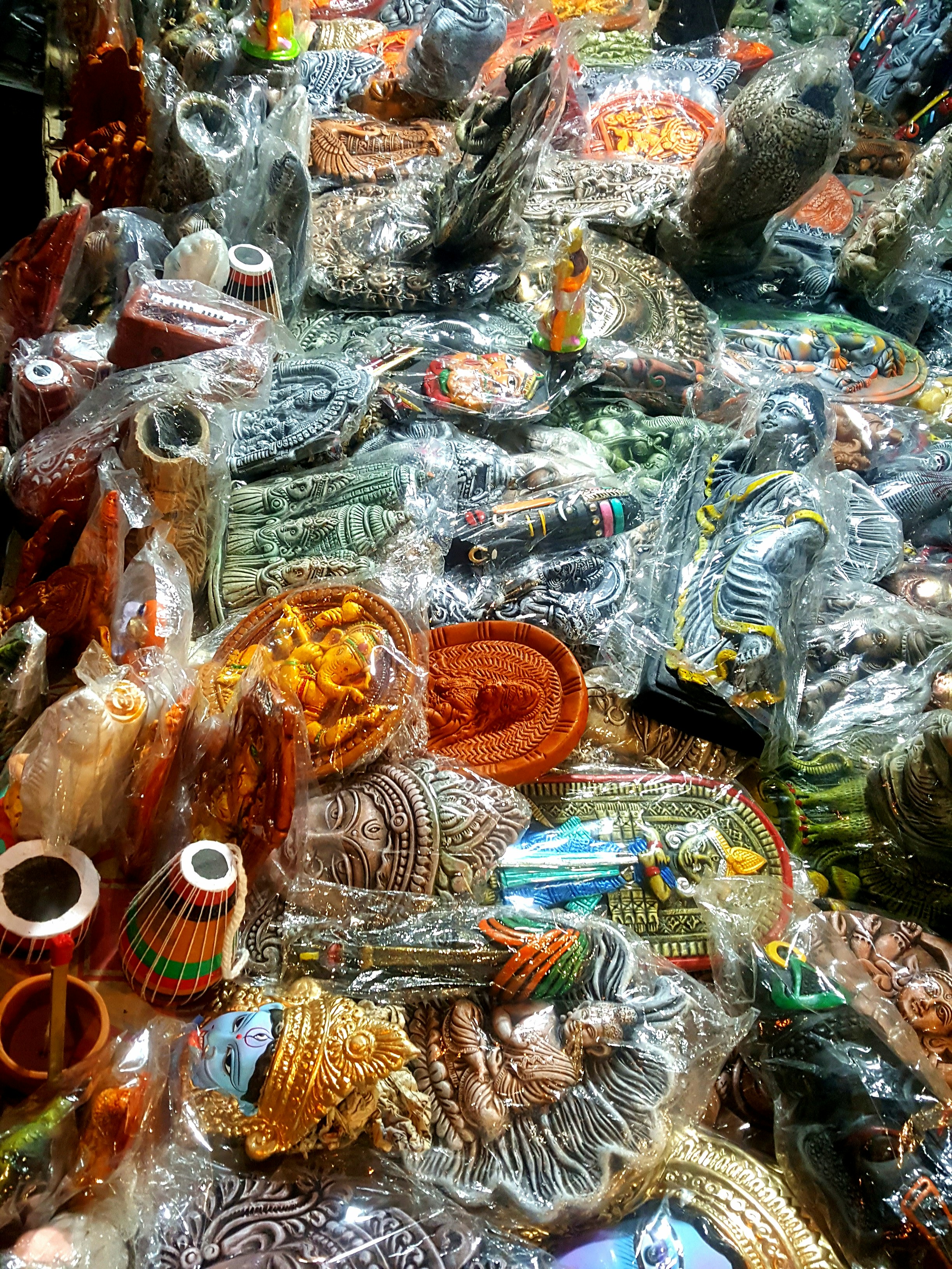 Vibrant assortment of intricately designed handcrafted artifacts arranged in a market setting, showcasing cultural craftsmanship.