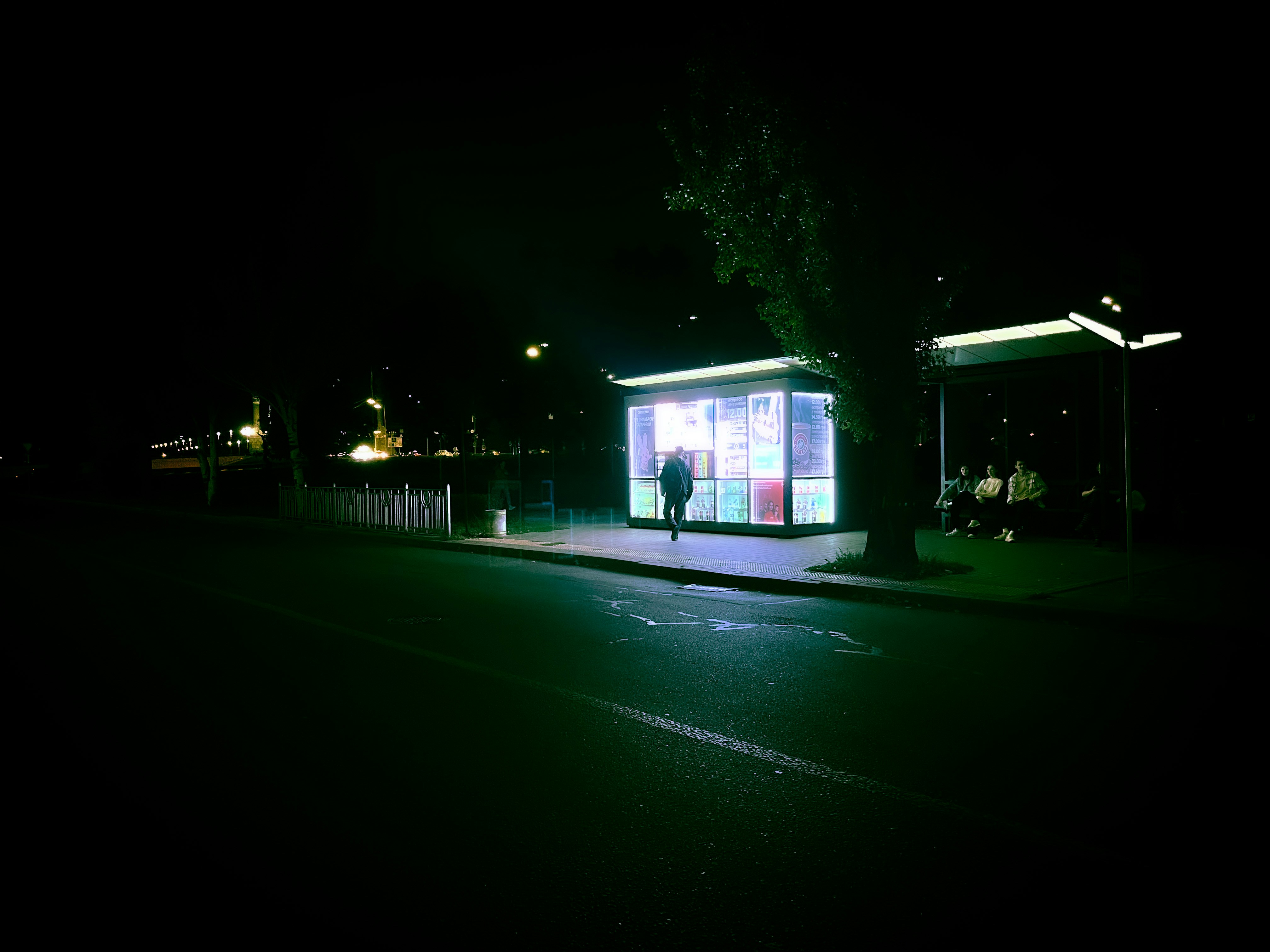A bus stop sitting on the side of a road at night photo – Free Bus stop ...