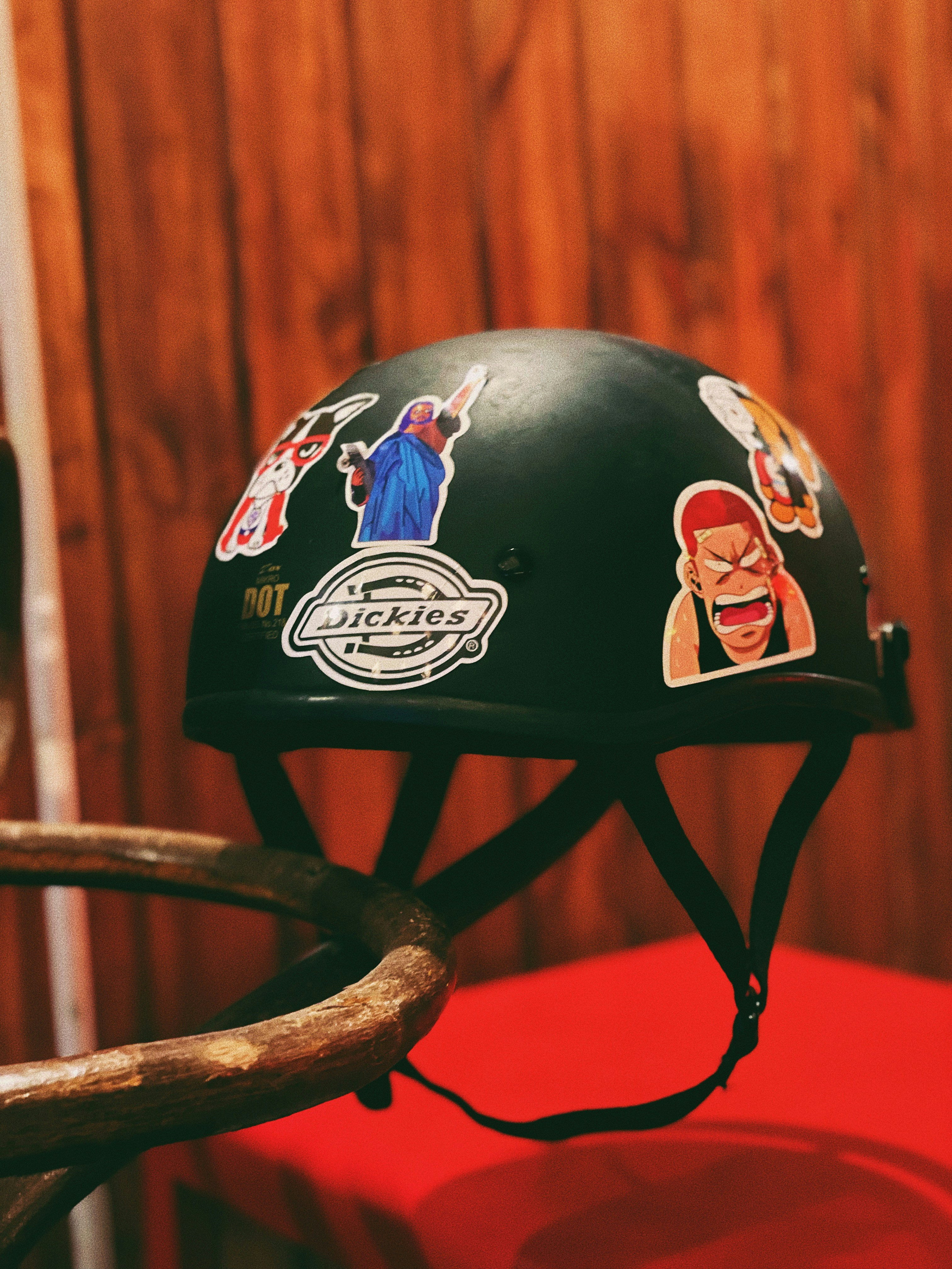 Stickered helmet resting on a red surface