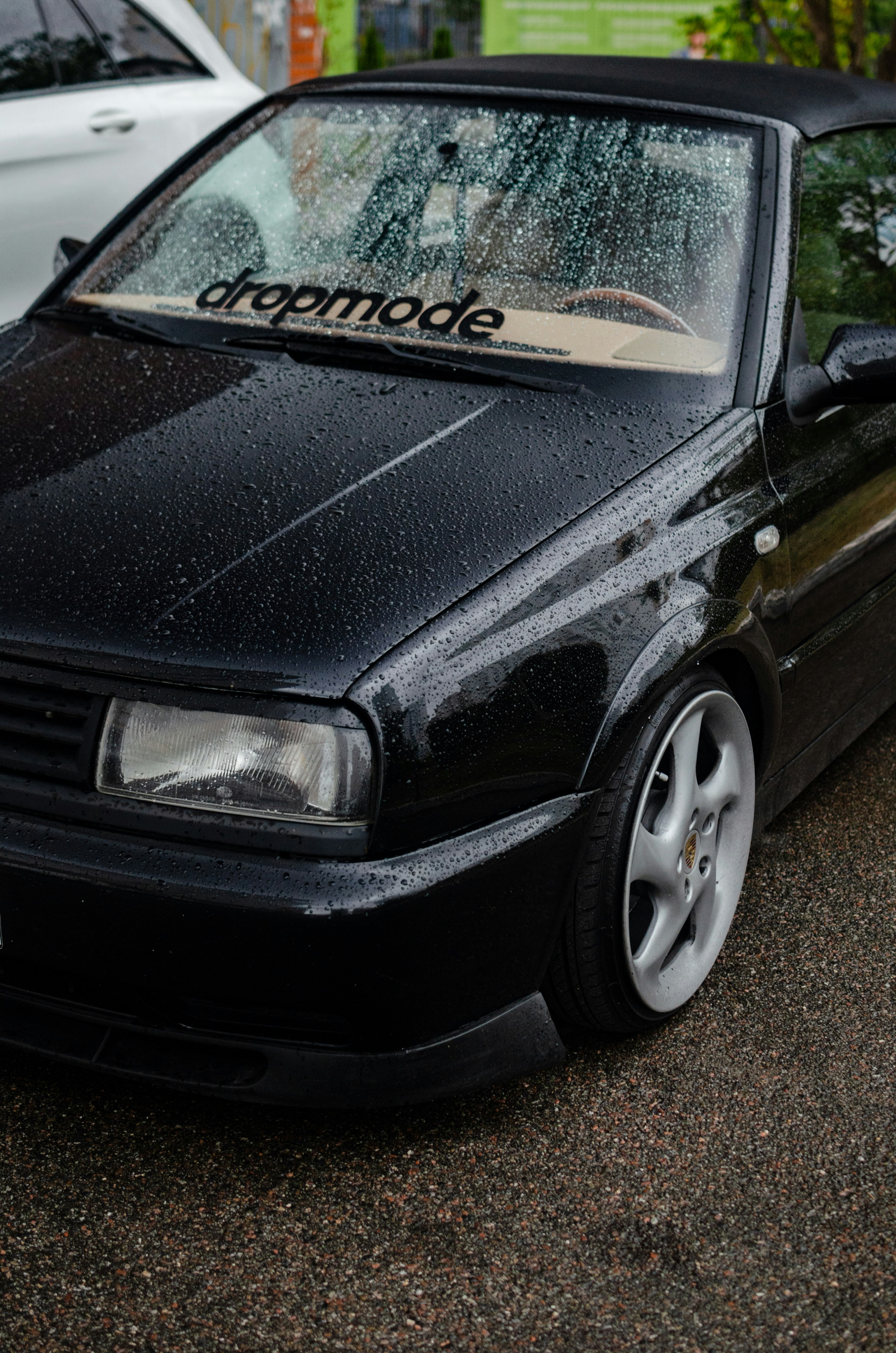 Rain-kissed DropMode: A Black Convertible's Wet Street Portrait