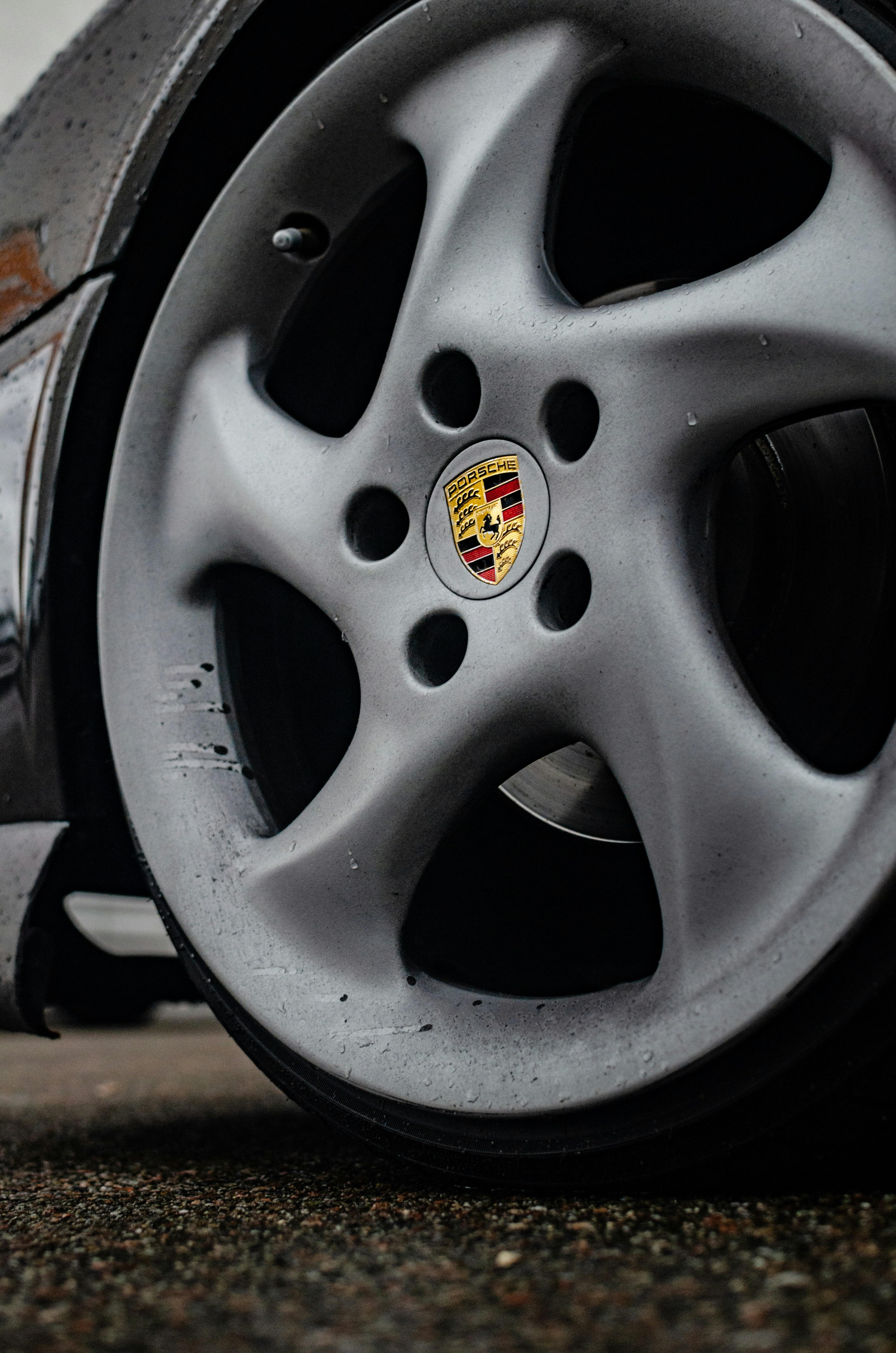 Wheel Close-Up: Porsche Crest on a Rain-Kissed Alloy