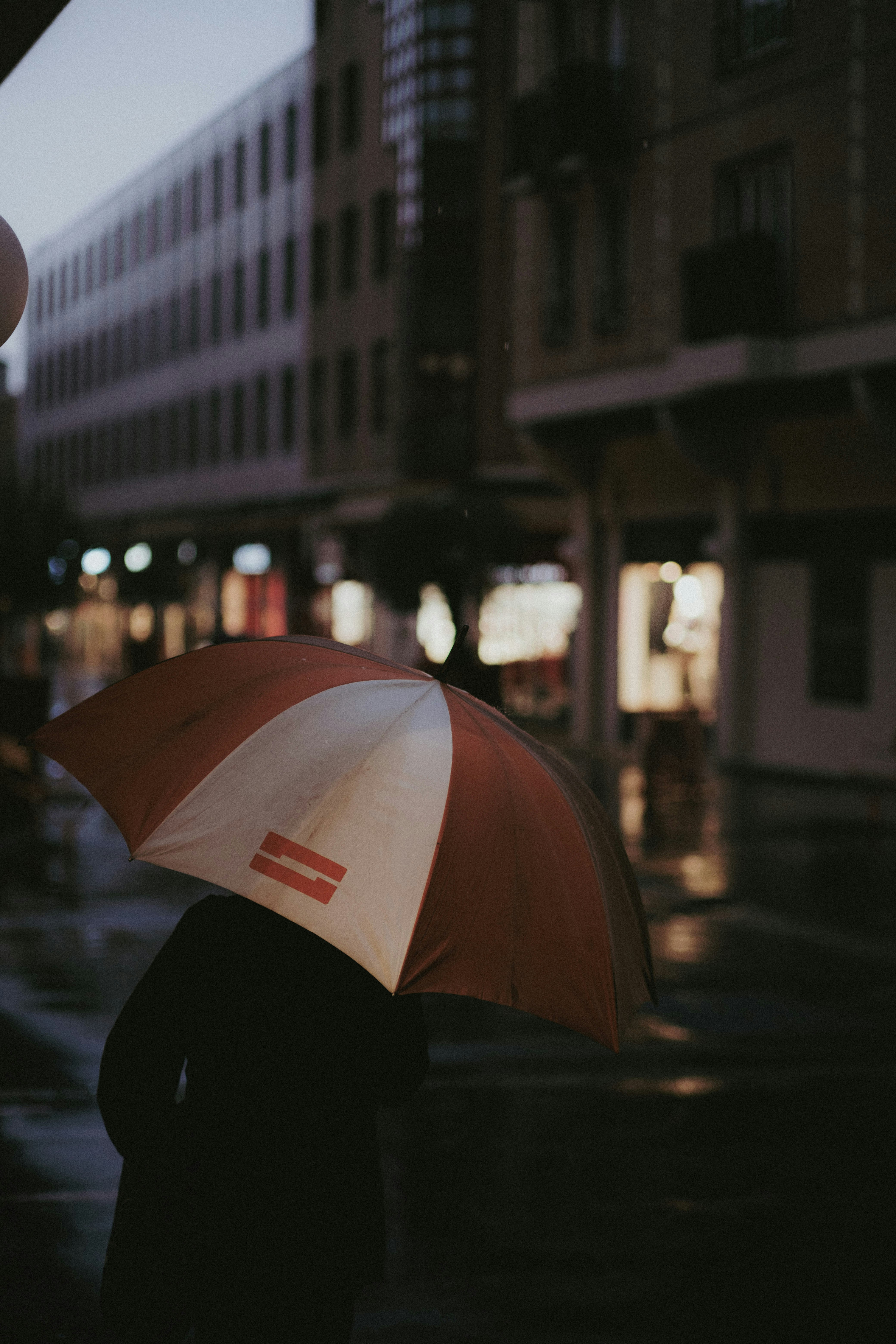 a person walking down a street holding an umbrella