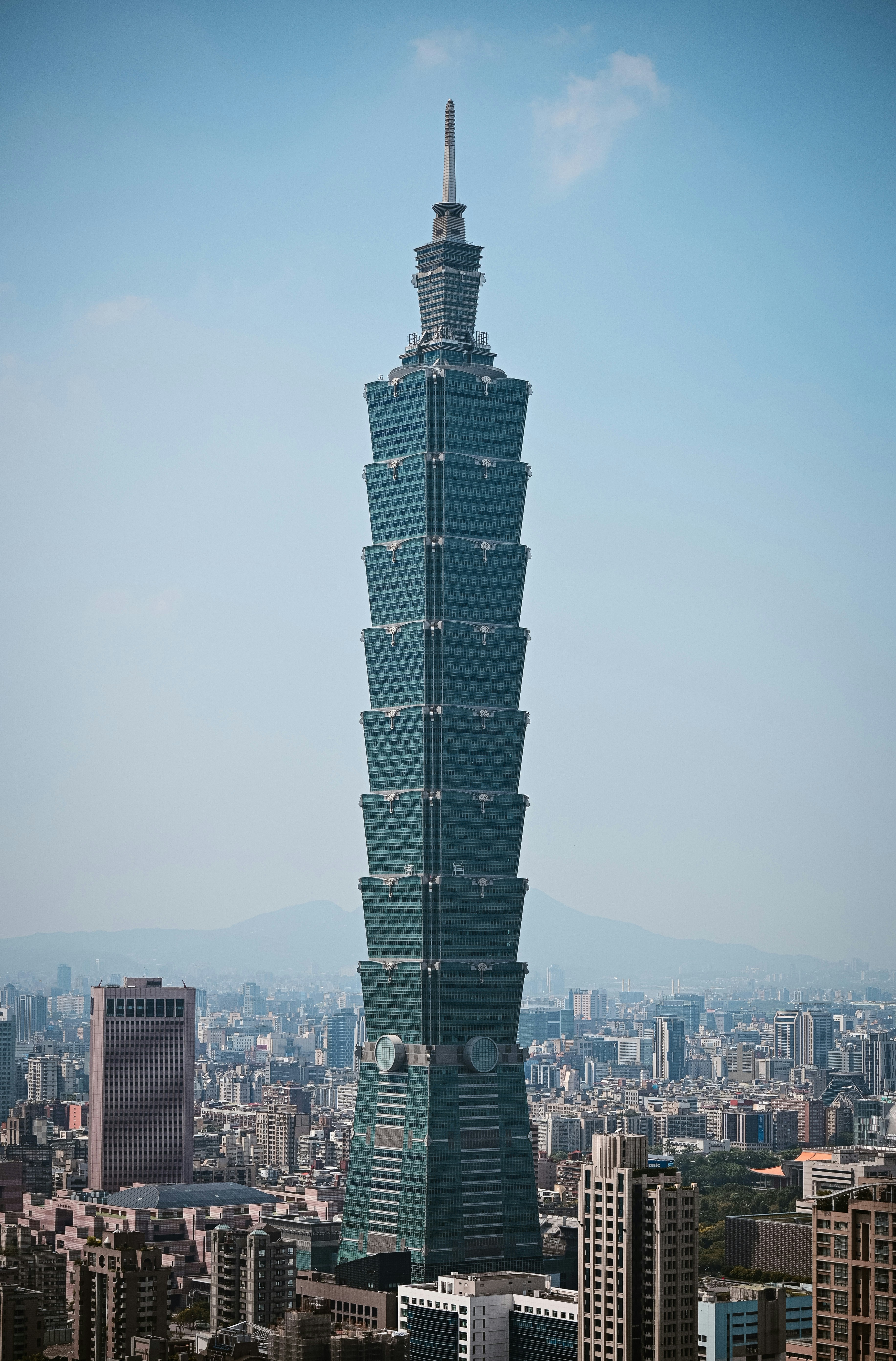 Taipei 101 rises majestically above the cityscape, showcasing its unique architectural design against a clear blue sky.