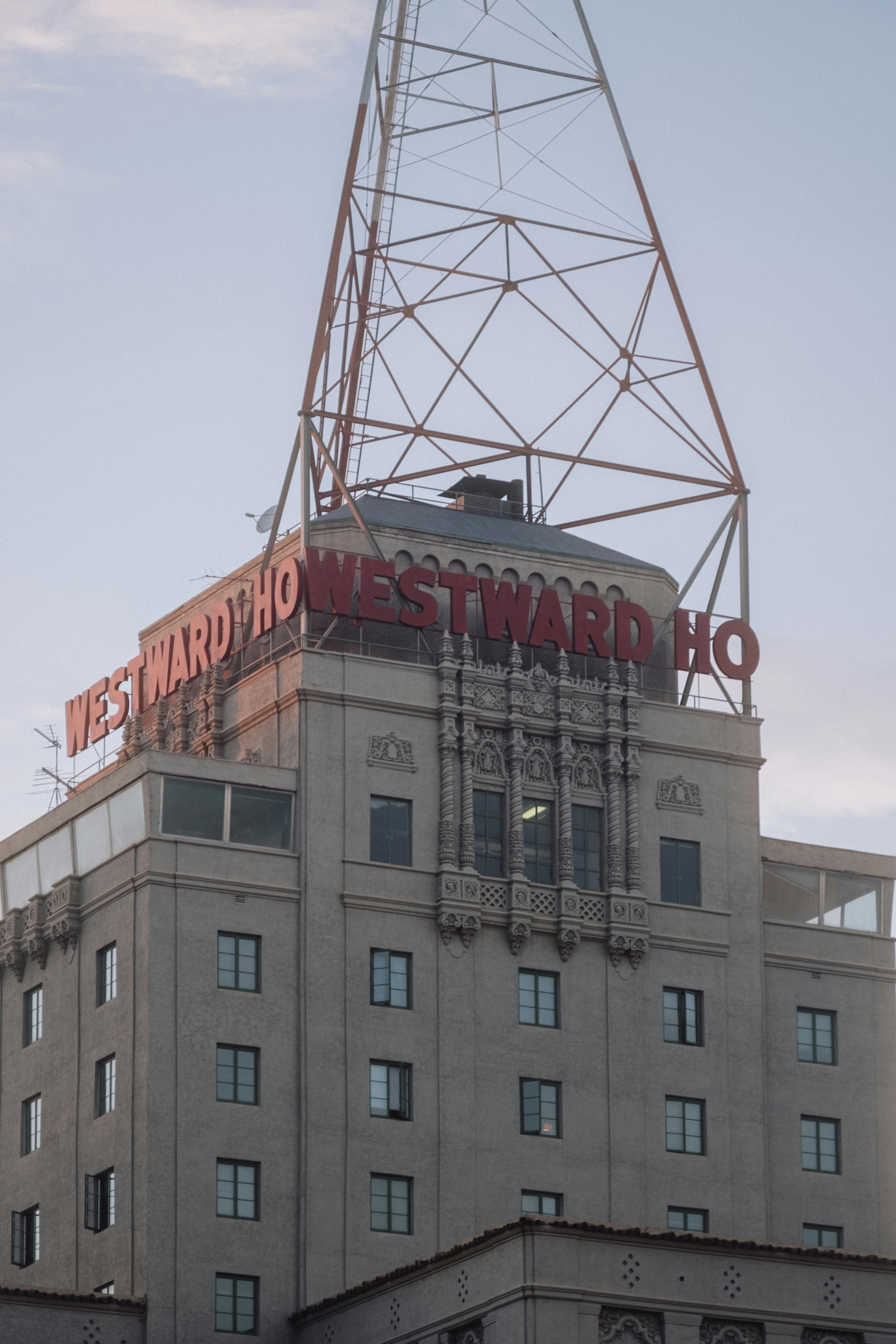 Historic building featuring the iconic 'Westward Ho' sign atop its art deco architecture, framed against a pastel sky.