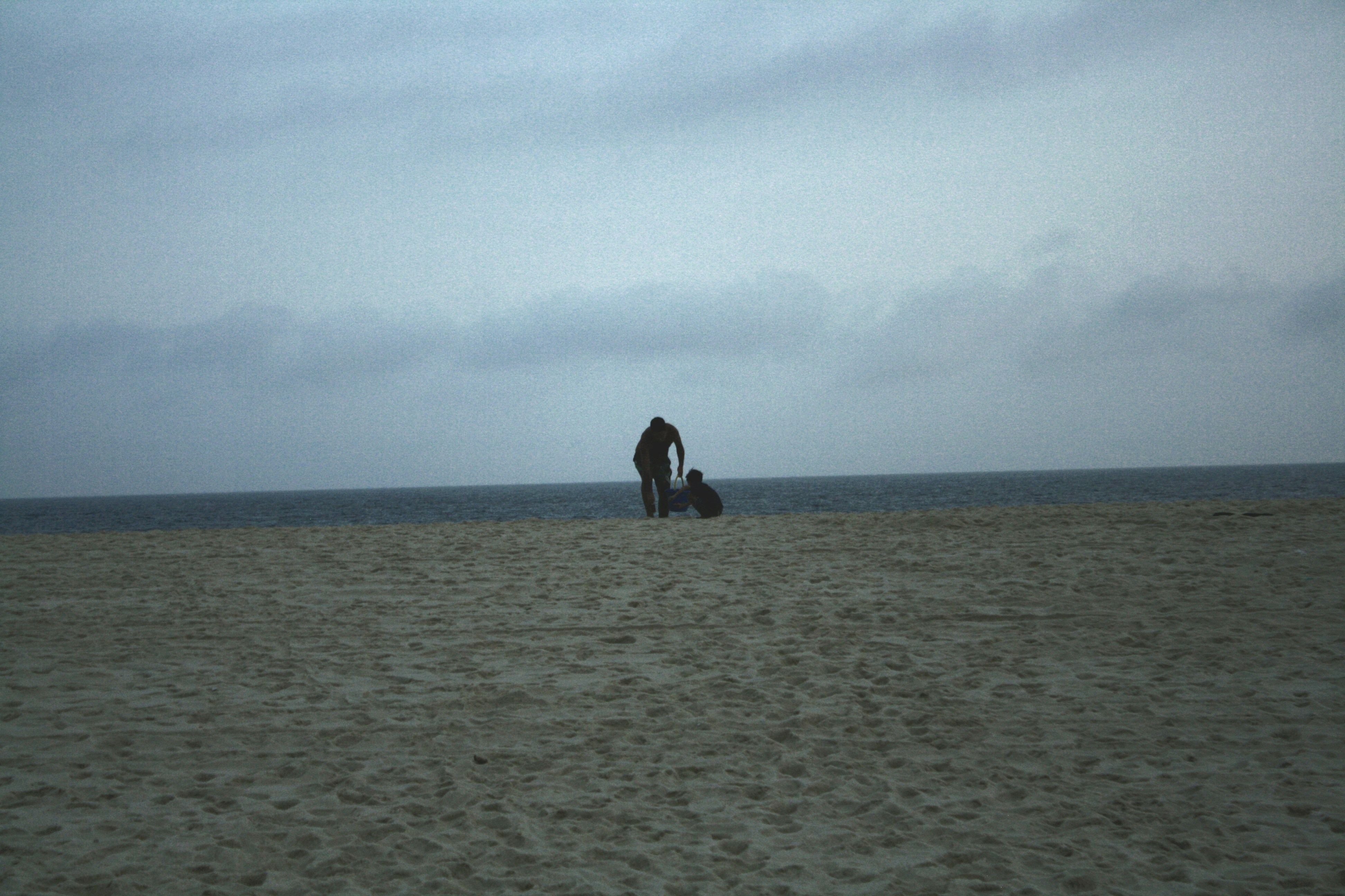 Two Figures on a Quiet Dune: A Subtle Beach Moment