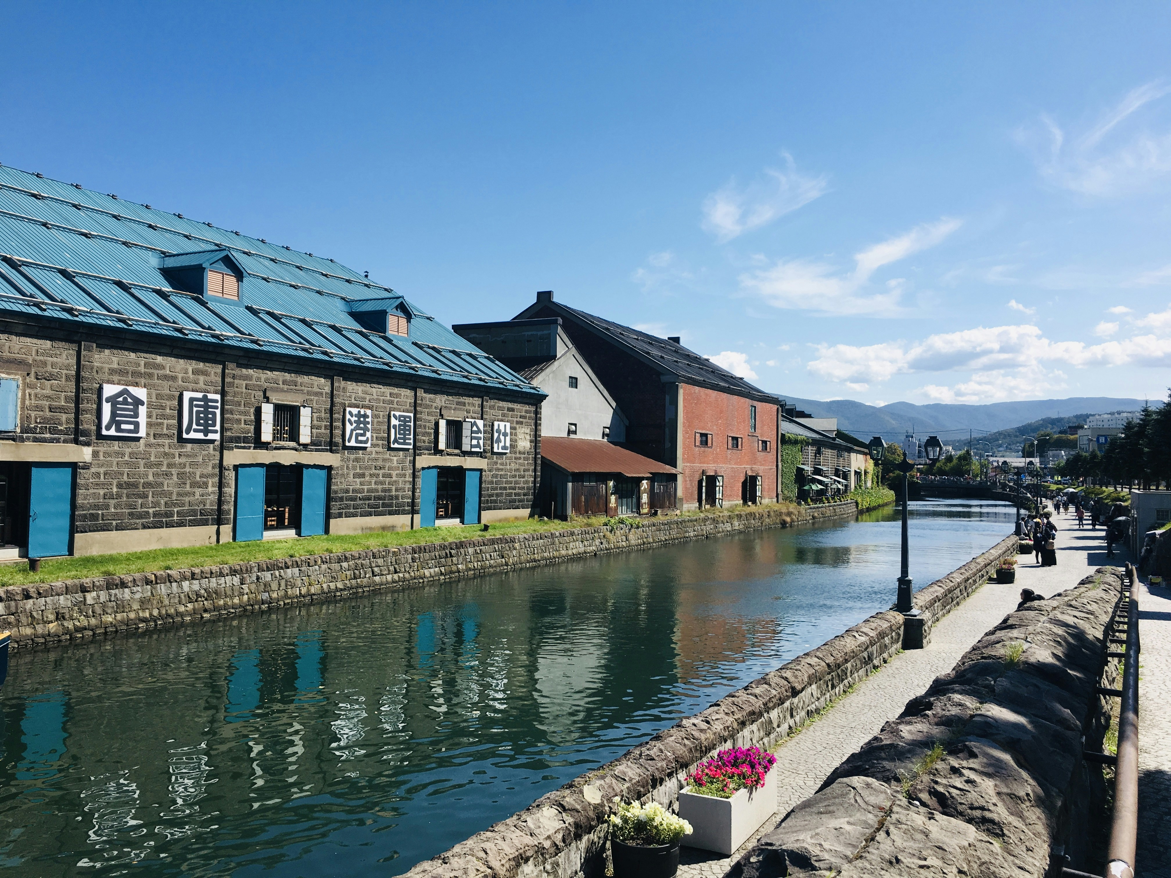 Blue-Roofed Warehouses Along a Sunlit Canal Walk