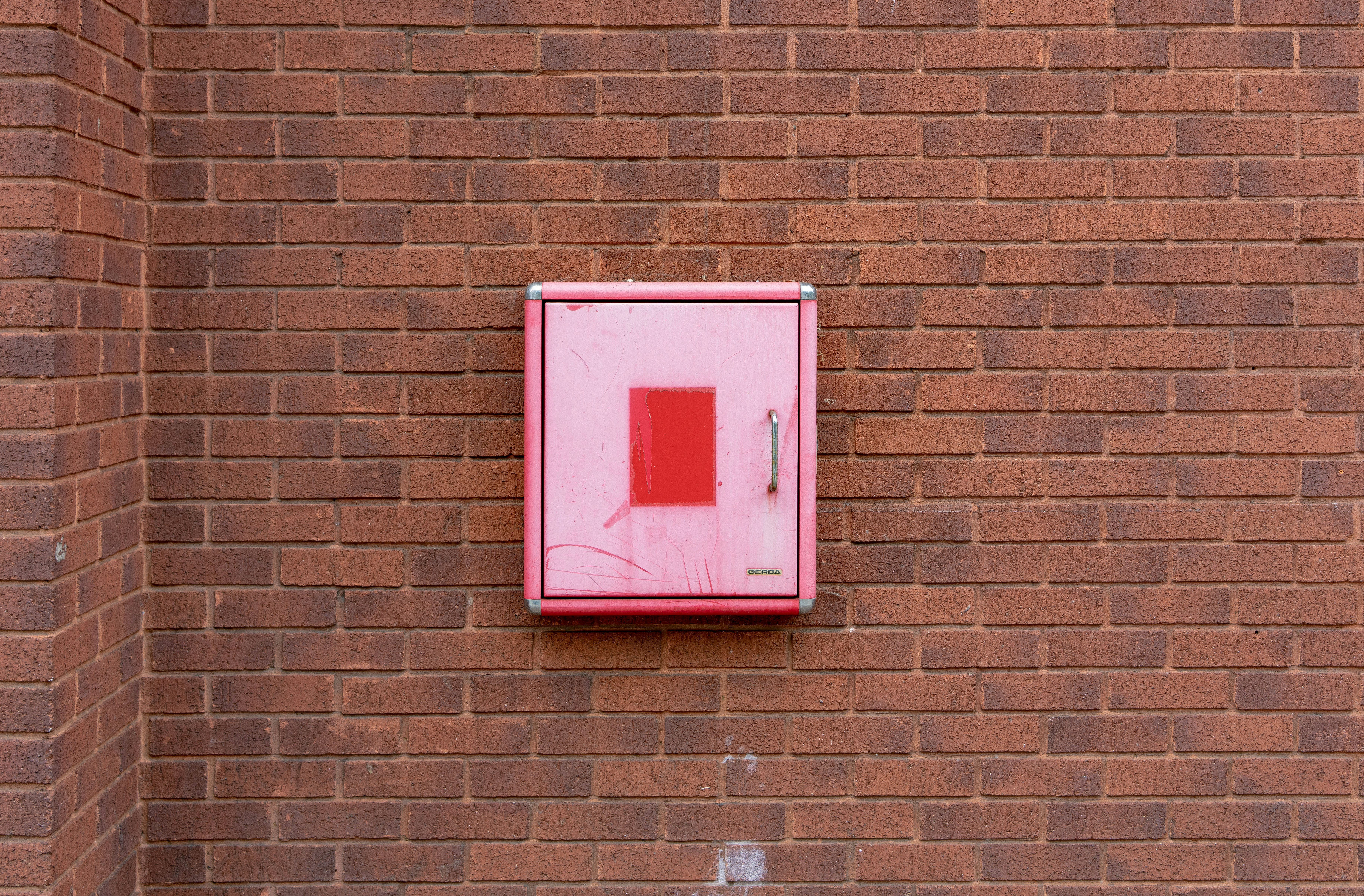 The Pink Utility Box Anchored to Red Brick
