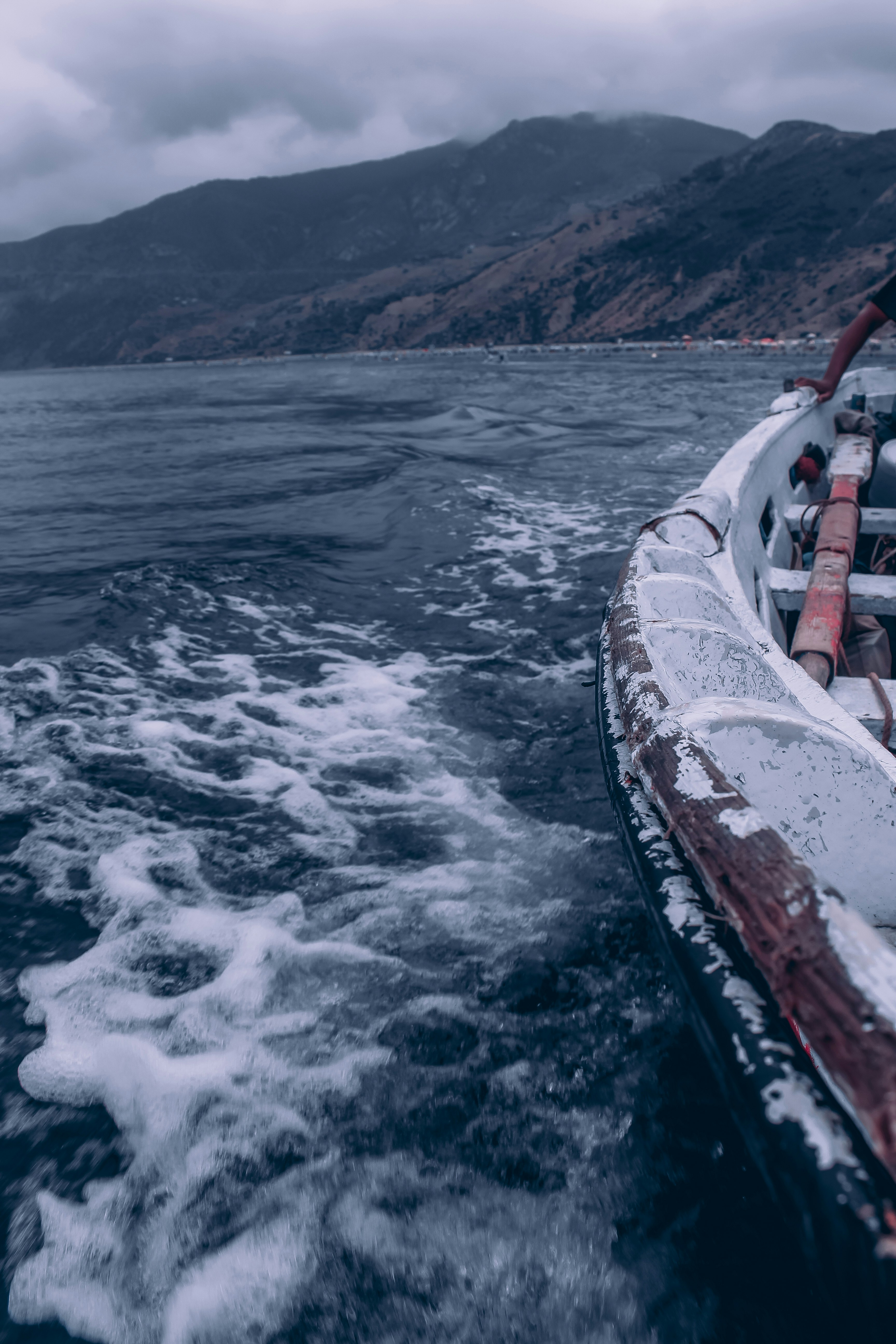 Rough Wake: A Weathered Boat Cuts Through Quiet Seas