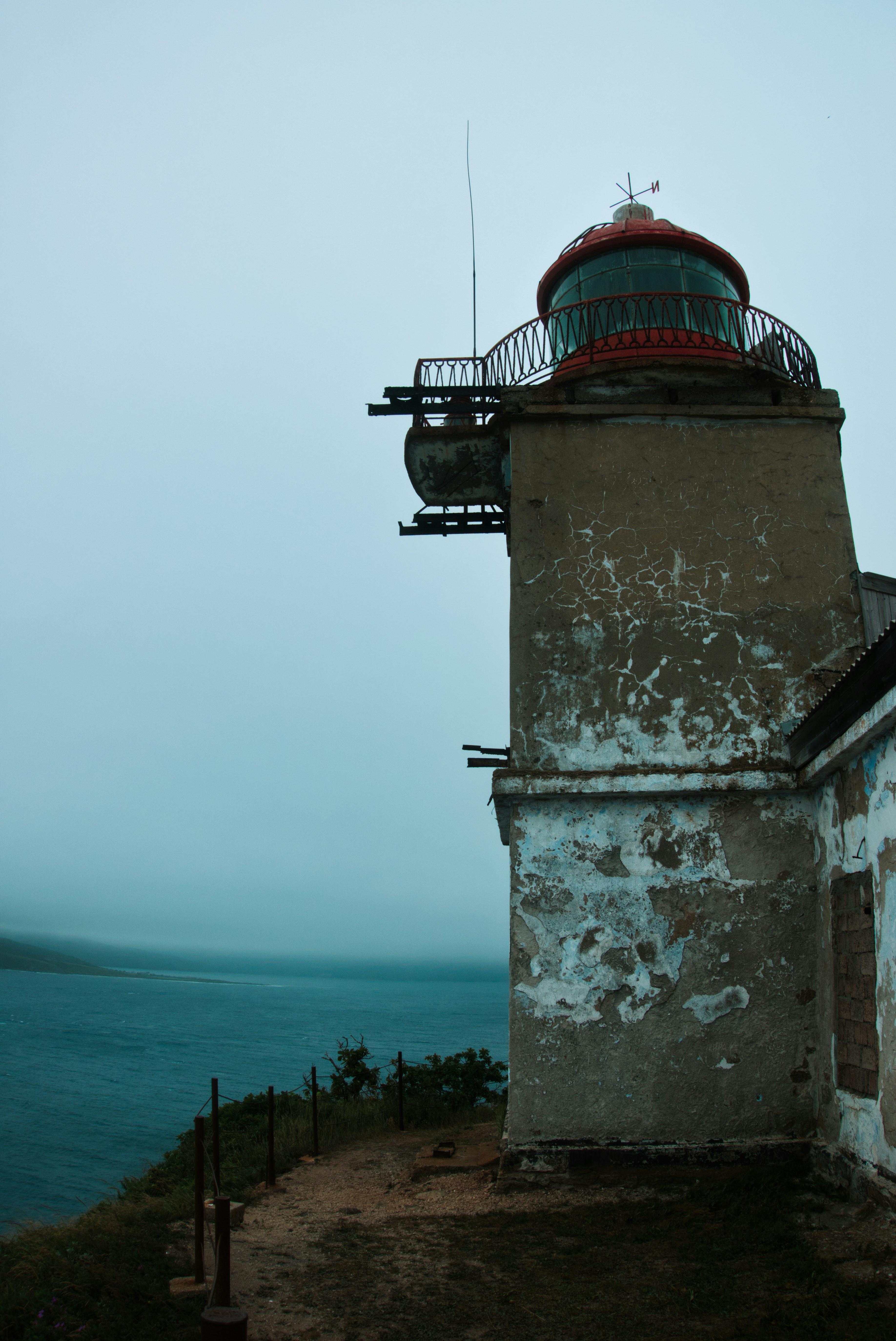 Lighthouse of Weathered Light Against a Misty Sea
