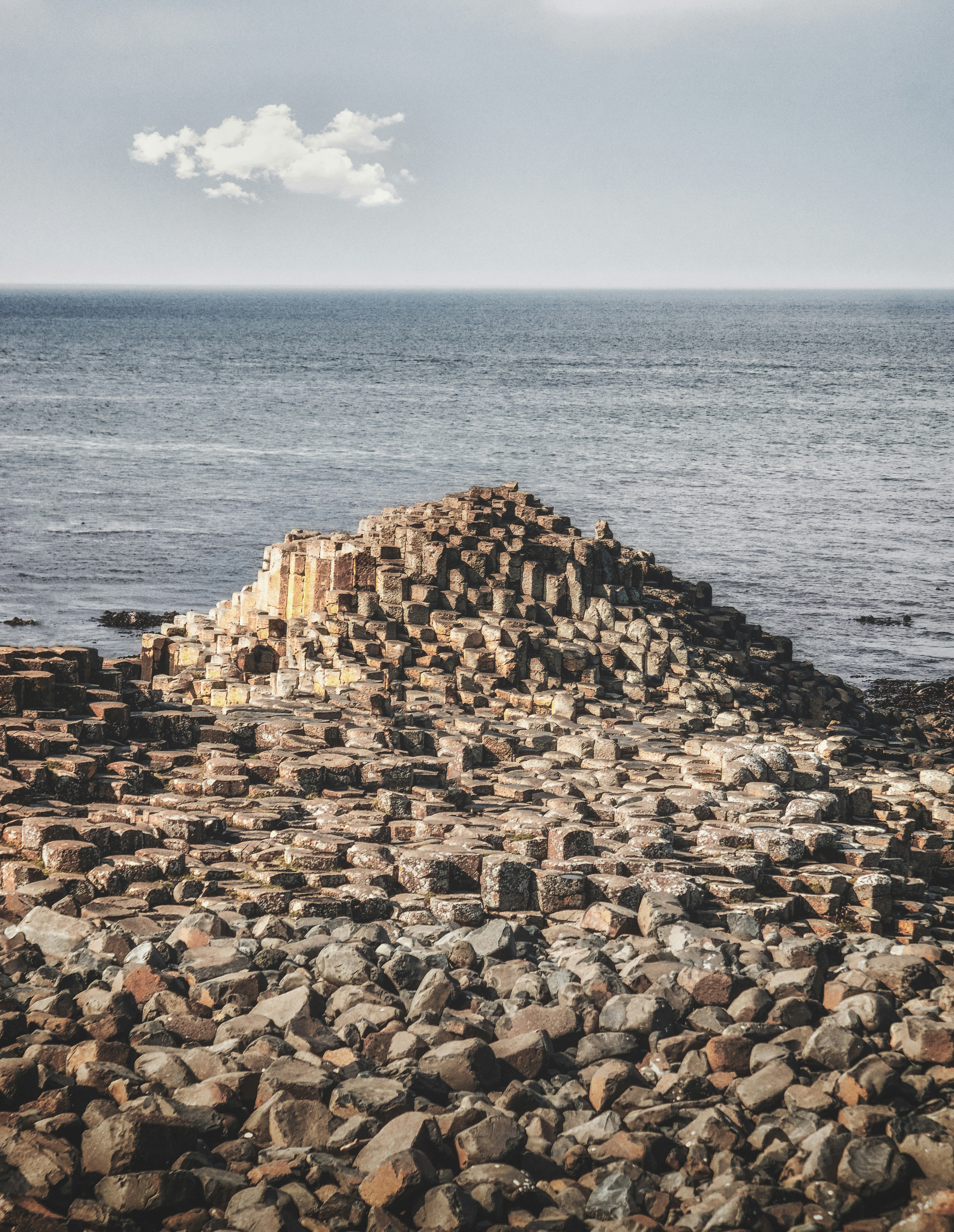A large pile of rocks sitting on top of a beach photo – Free Myth Image ...