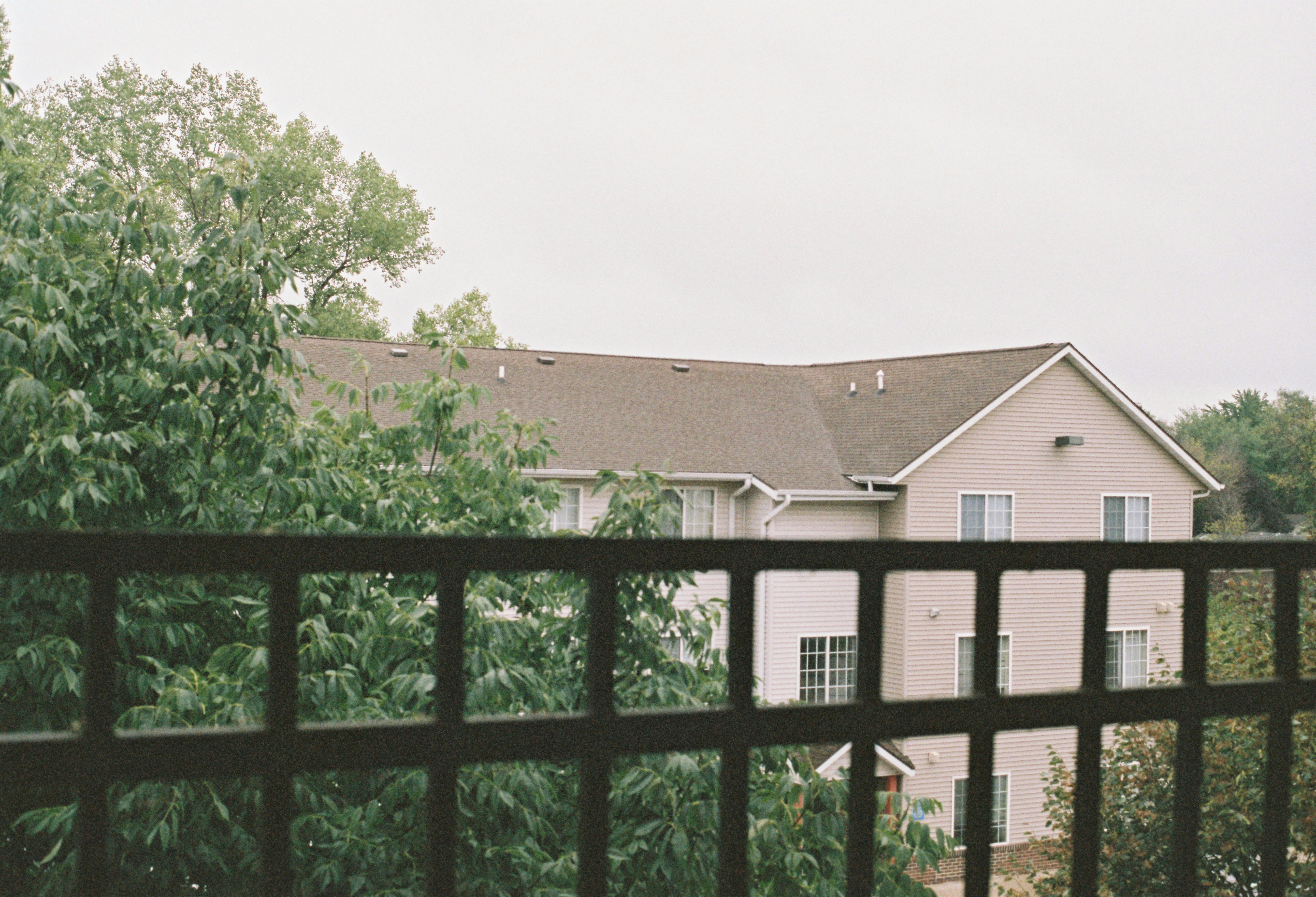 Rails in Focus: Quiet Suburban Vista Framed by Balcony and Trees