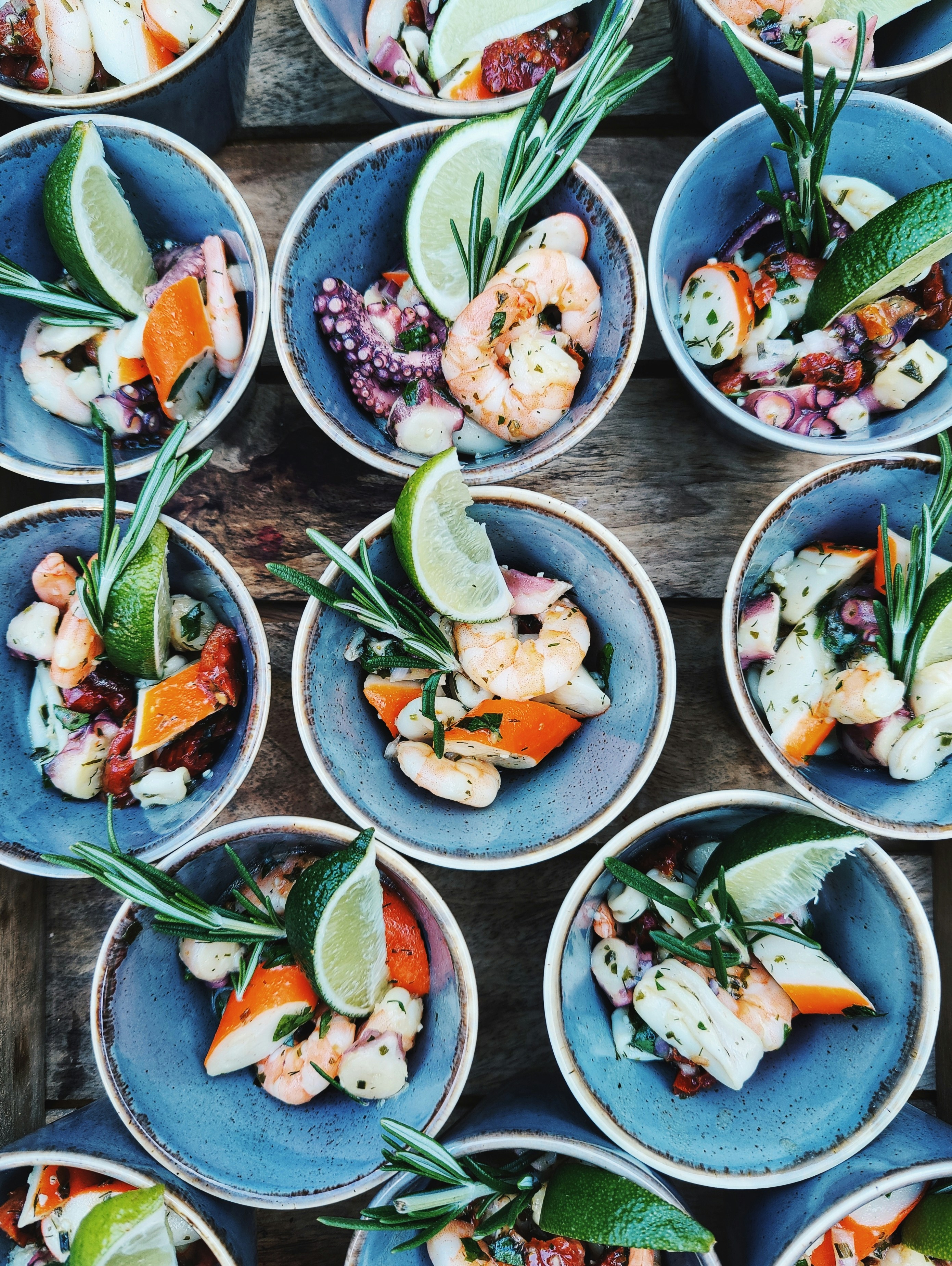 Colorful seafood ceviche served in rustic bowls, garnished with fresh herbs and lime wedges.
