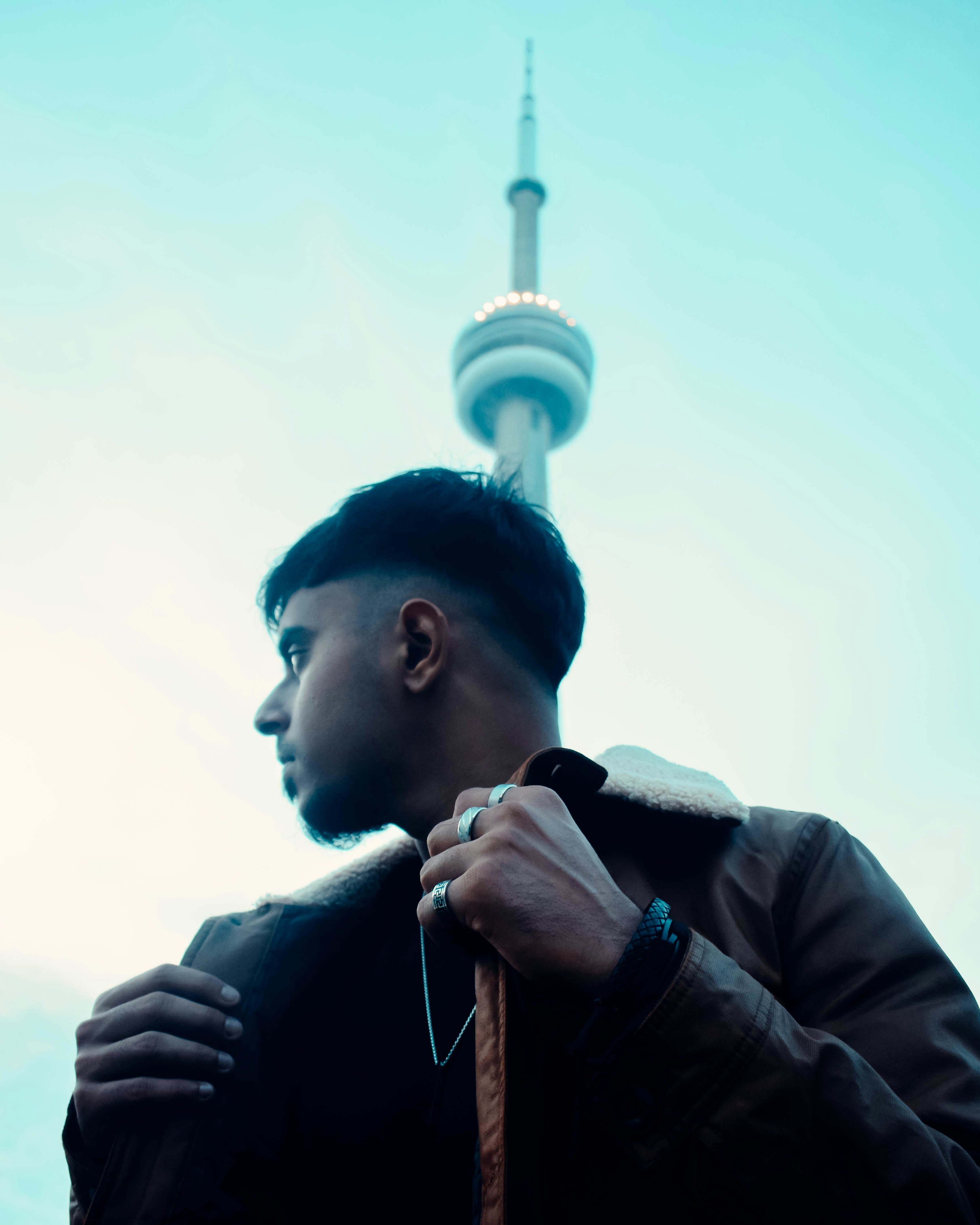 Rooftop Gaze: Portrait Beneath a Towering Sky