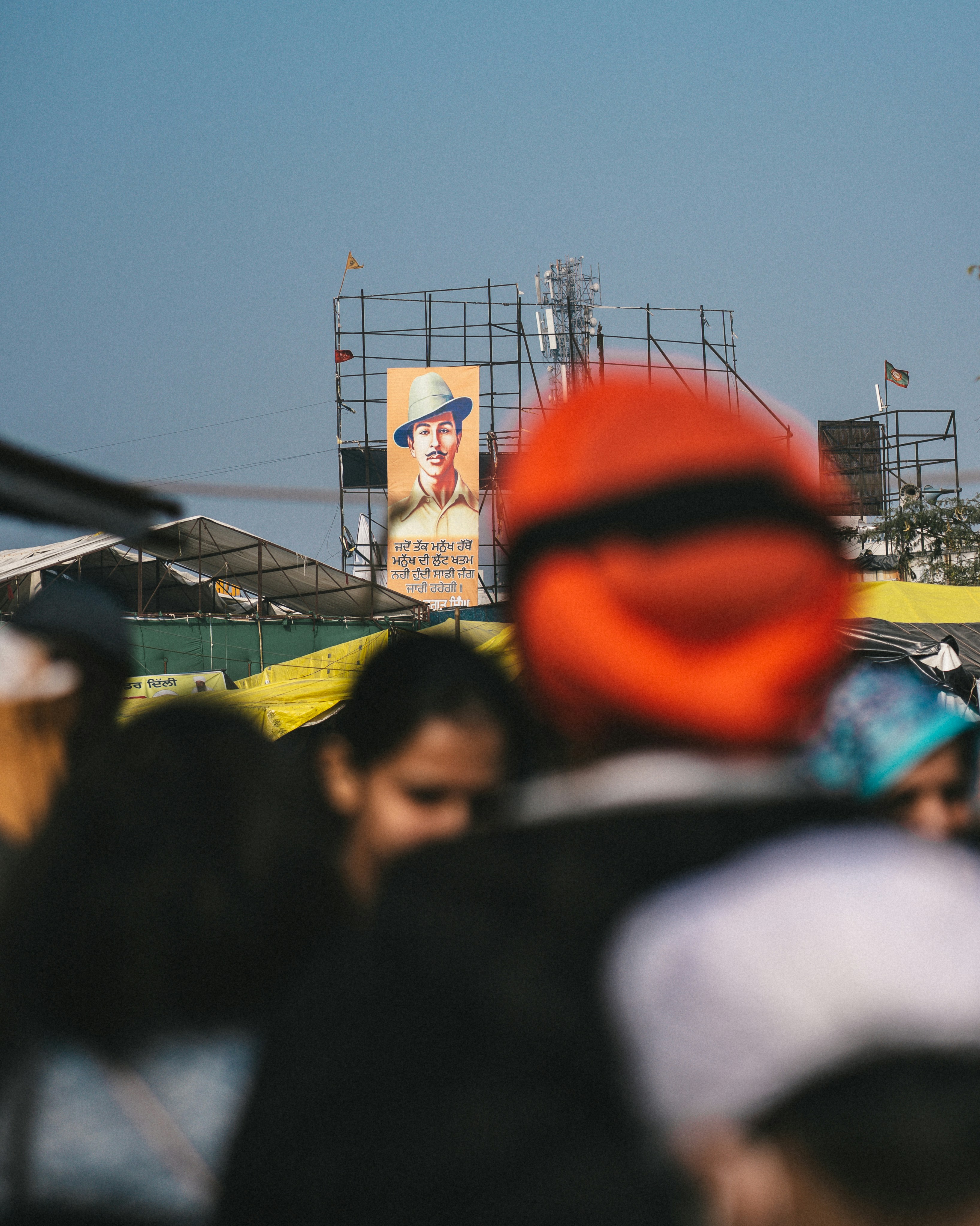 Poster Portrait Amid Market Blur: A Heroic Figure Watches Over a Busy Festival