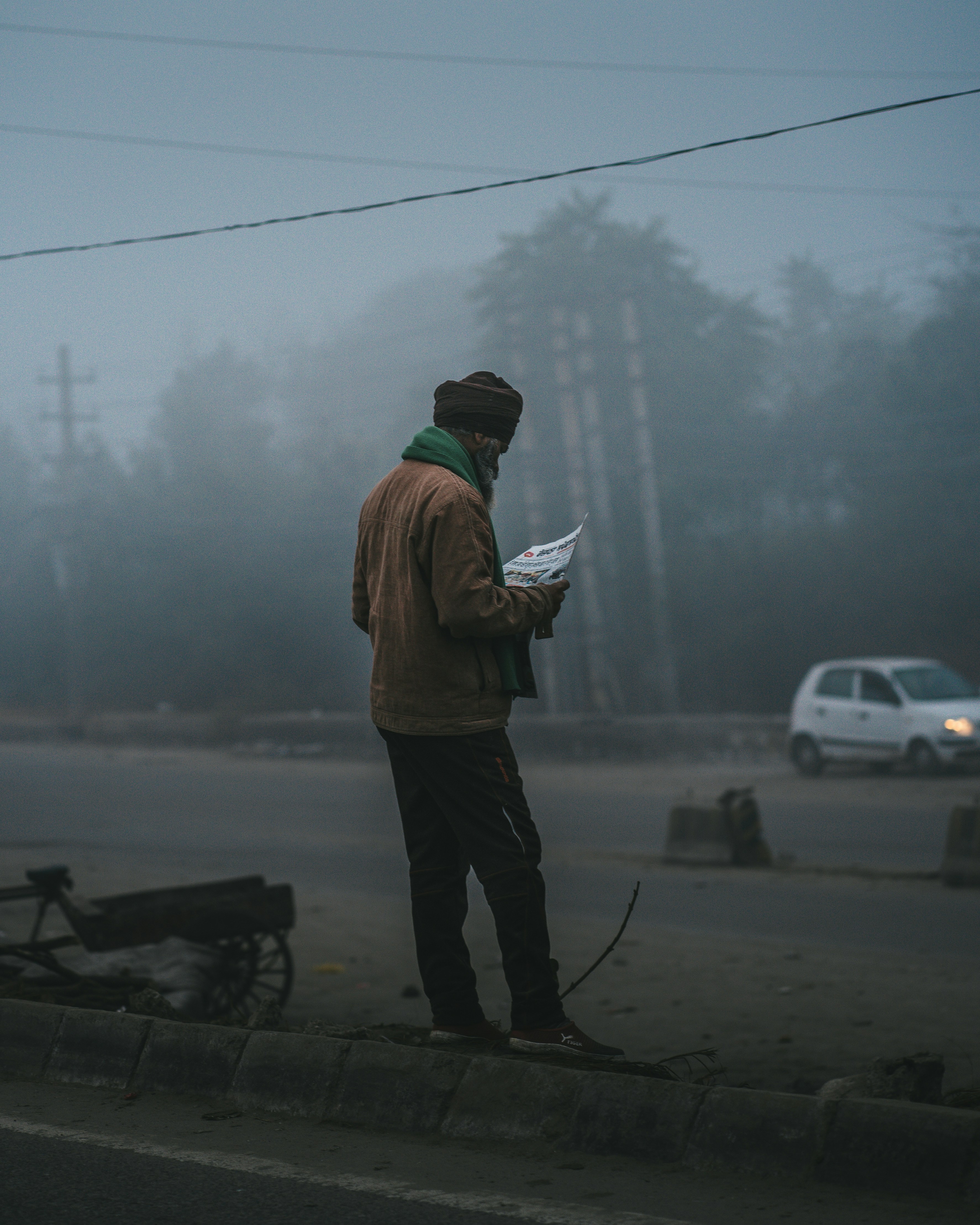 Mist-Lit Pause: A Street Reader in Fog