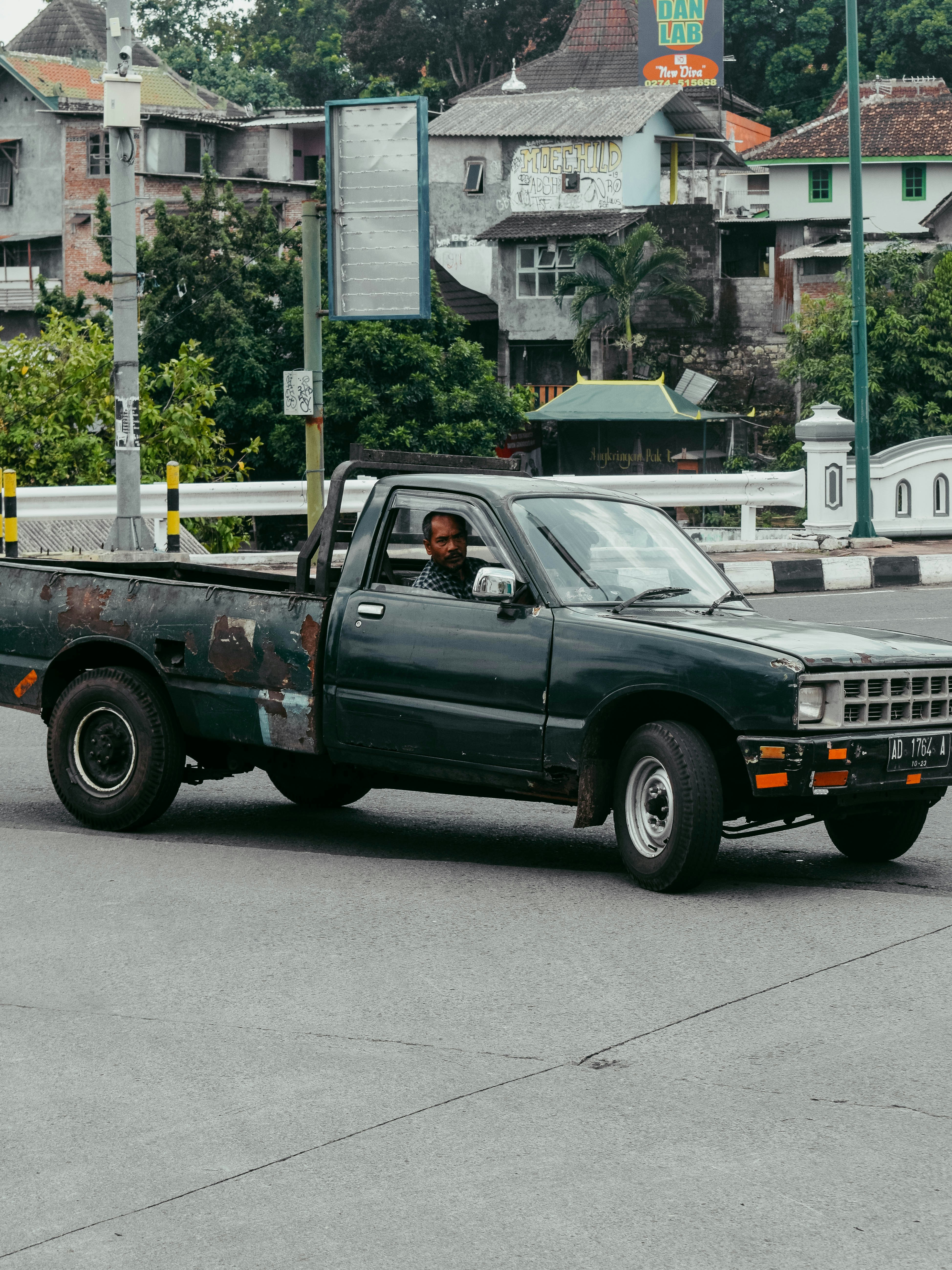 Grit on Wheels: A City Driver in a Weathered Green Pickup