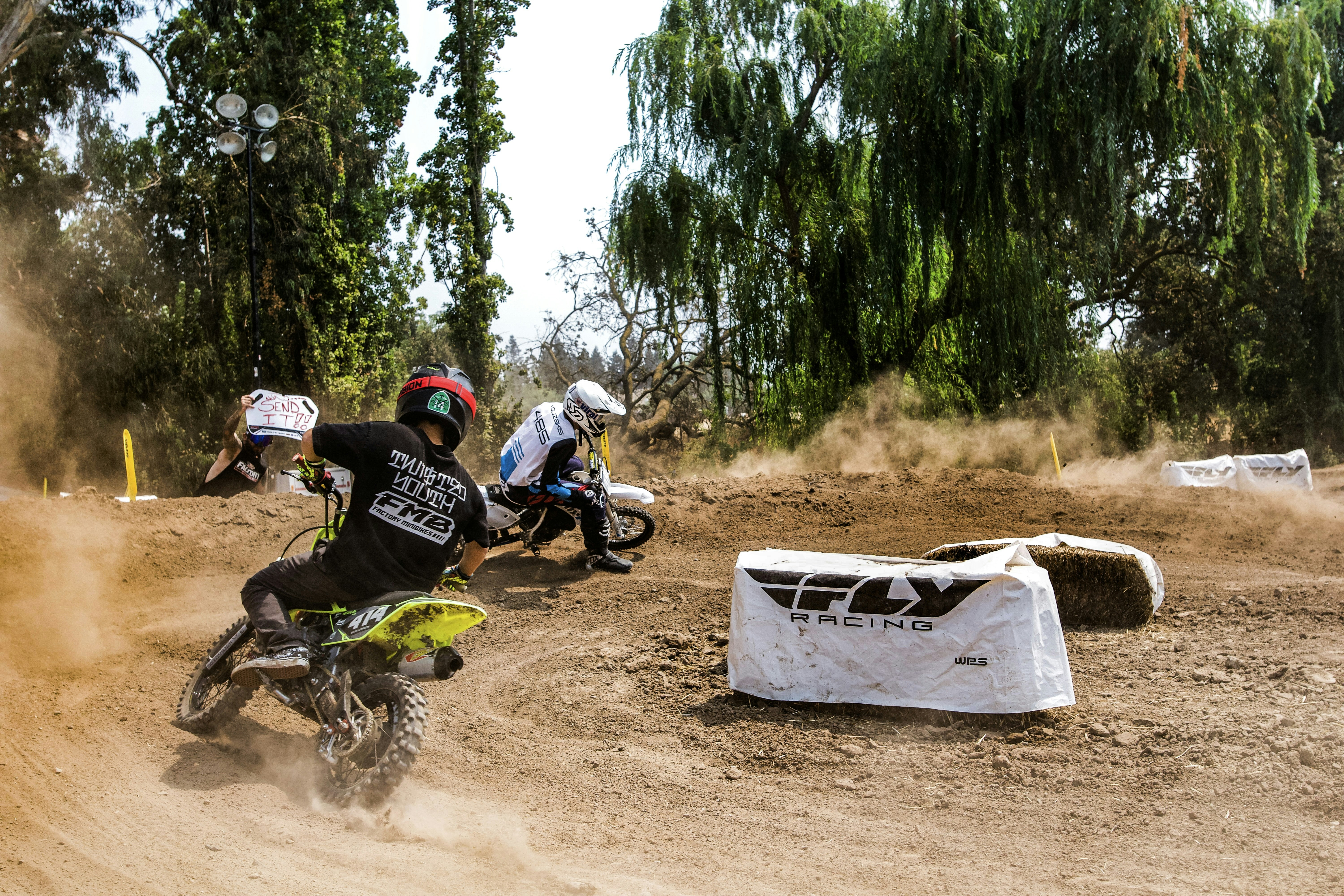 A couple of people riding dirt bikes on a dirt track photo – Free ...